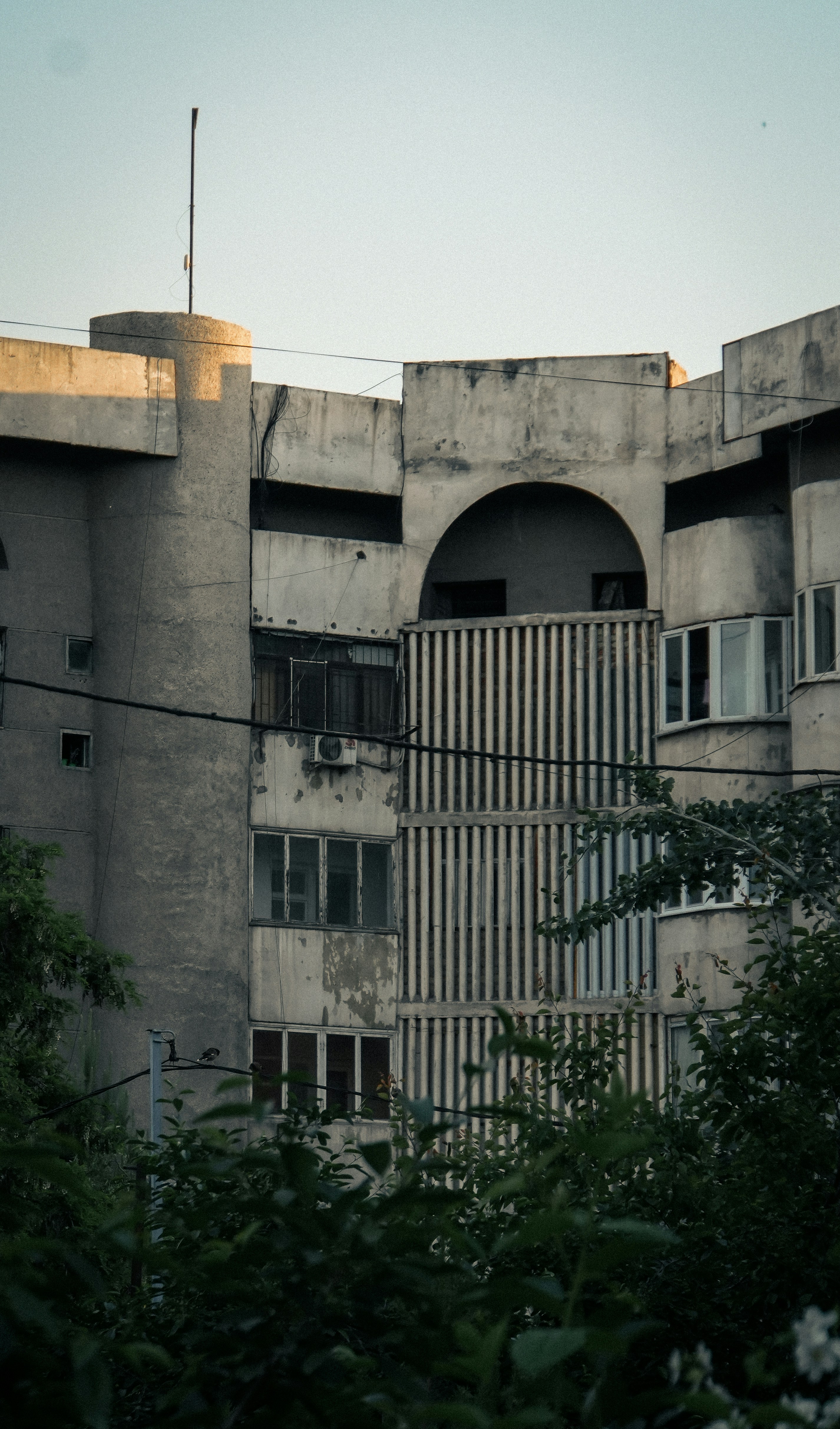 Archlight Over the Weathered Facade: Concrete Geometry at Dusk