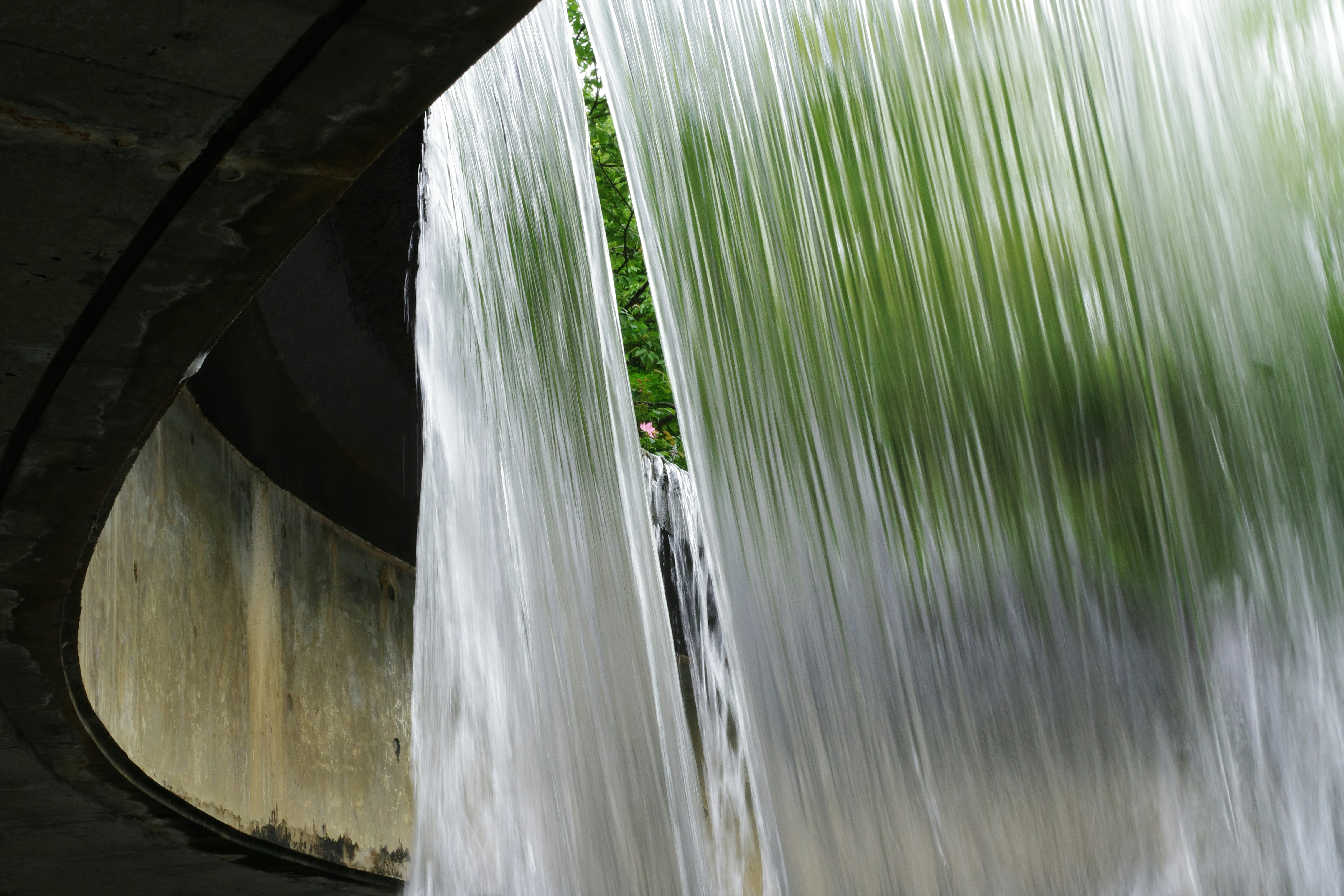 Archway Cascade: Light-Filtered Water Pouring Through a Culvert