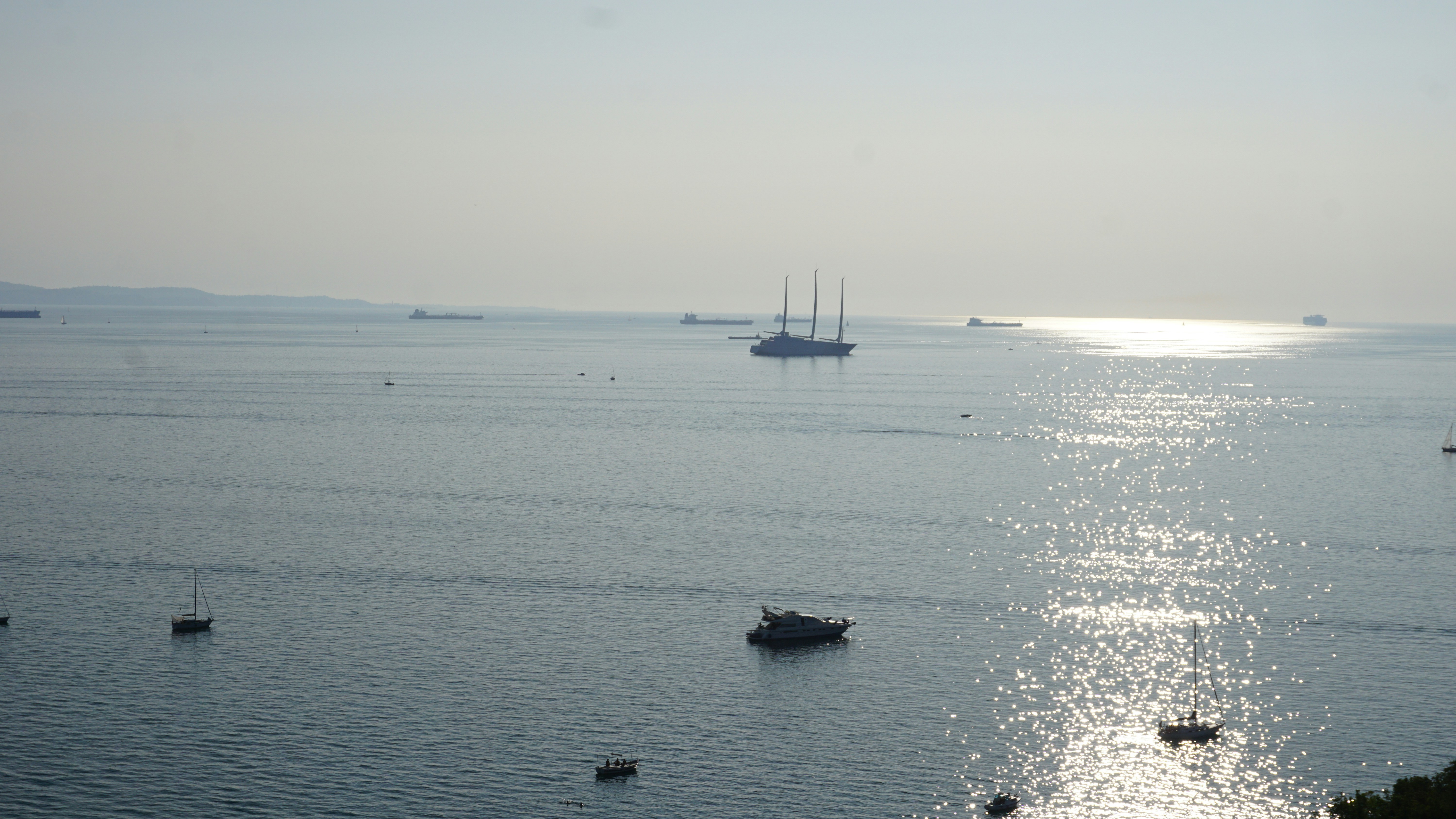 Glinting Horizon: A Central Sailboat in a Quiet Sea