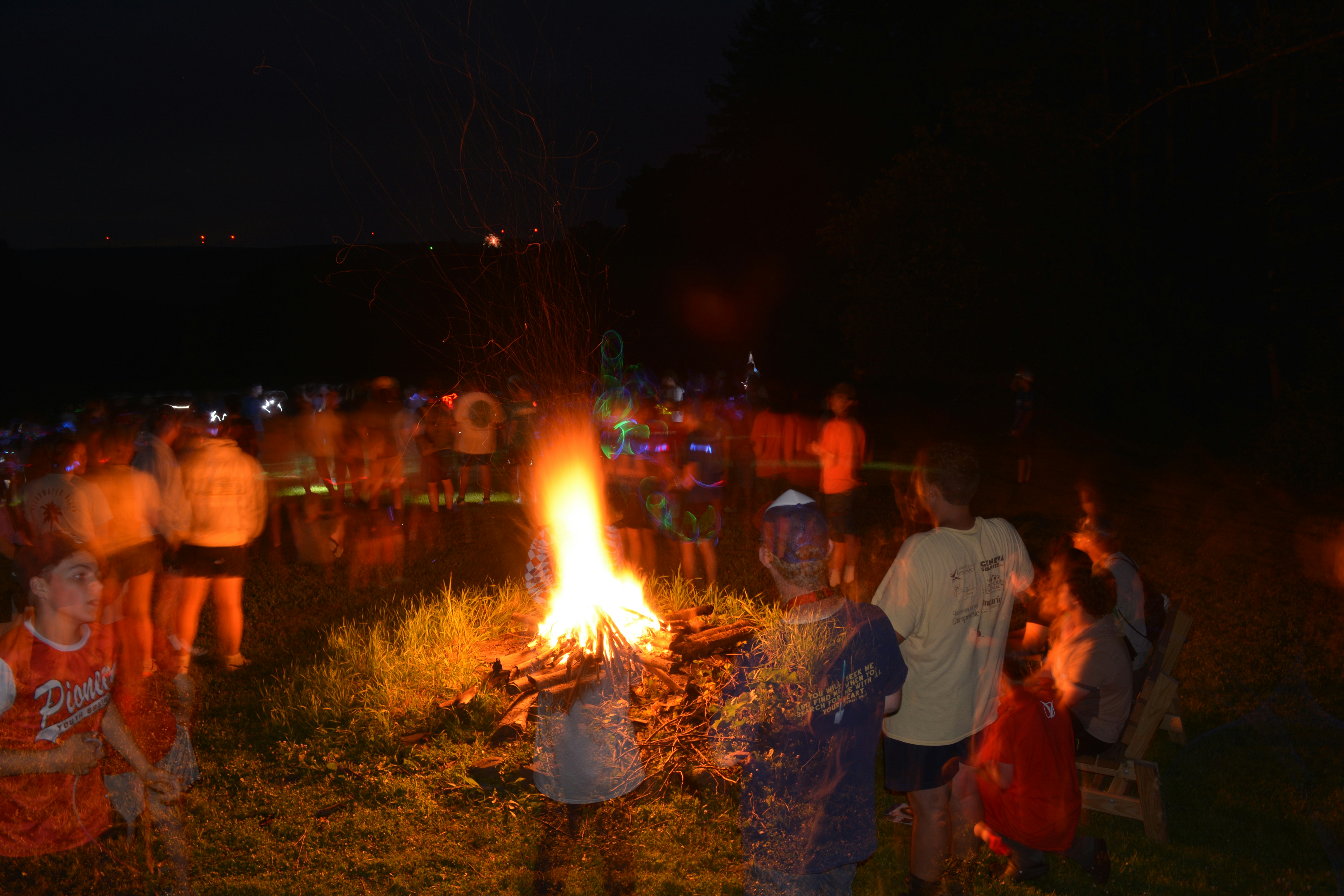 A group of people standing around a fire photo – Free Man Image on Unsplash