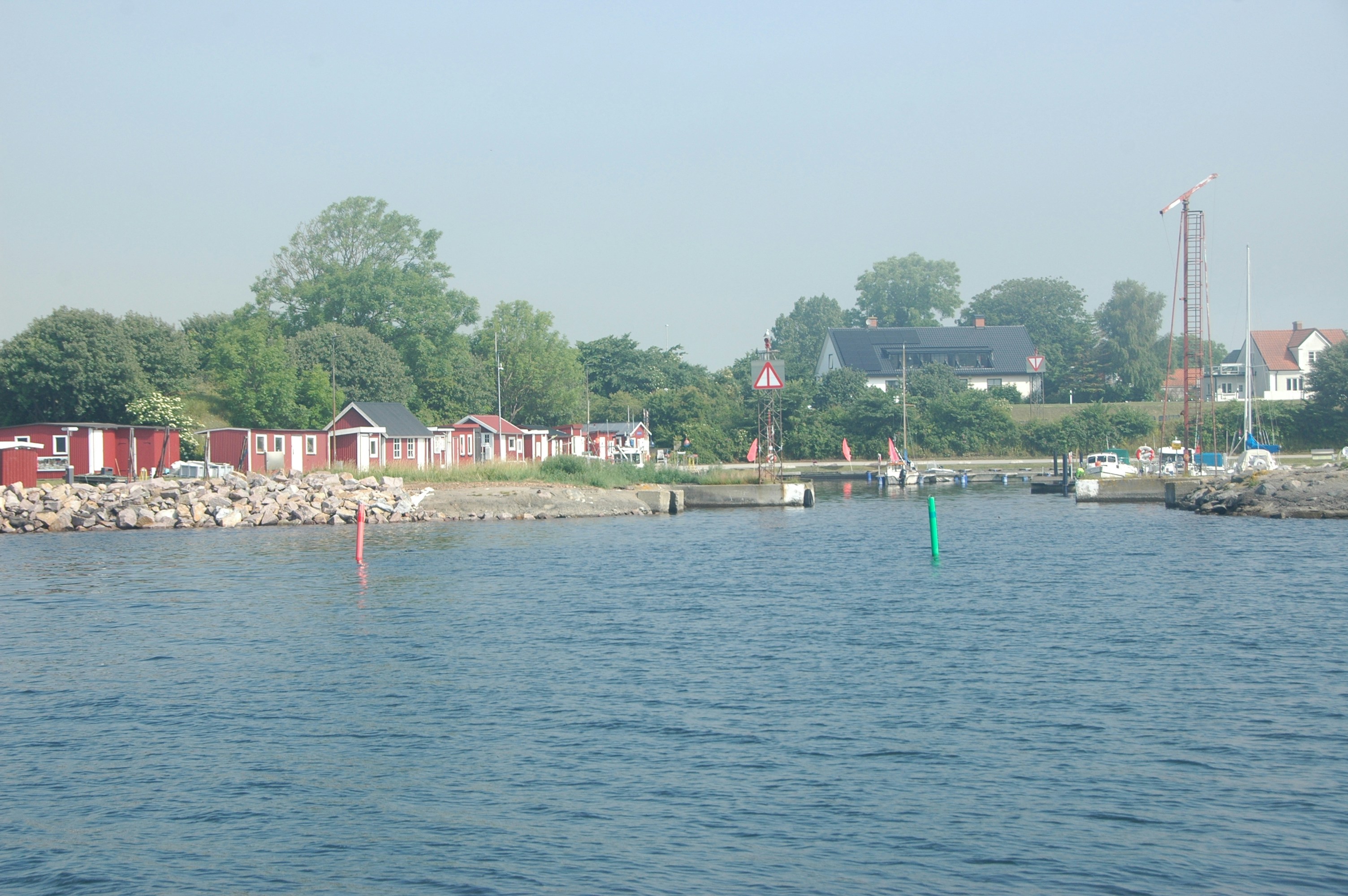 Red Boathouse Row Across a Calm Harbor Channel