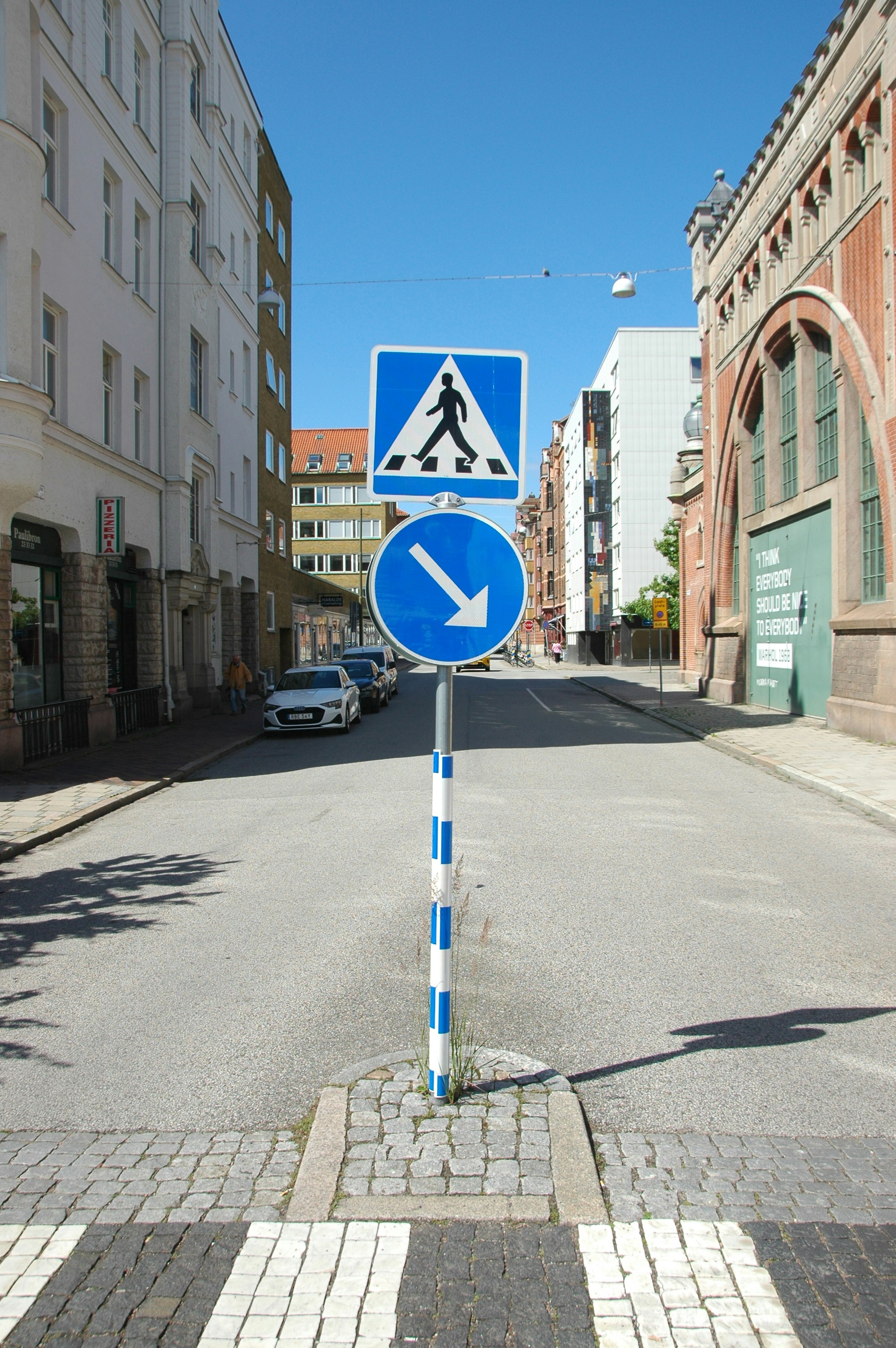 A blue and white street sign sitting on the side of a road photo – Free ...