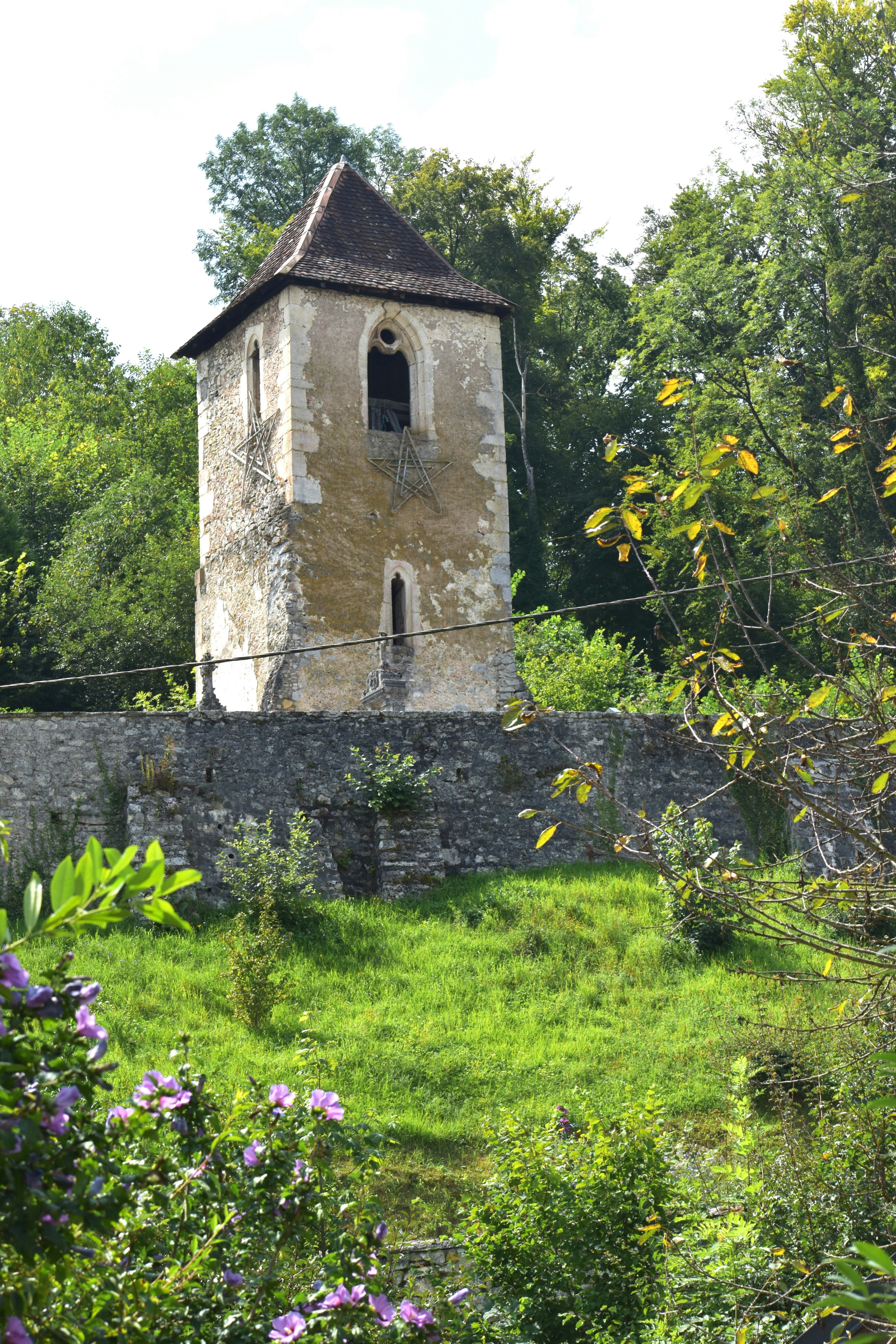 Weathered Bell Tower Surrounded by Lush Spring Growth