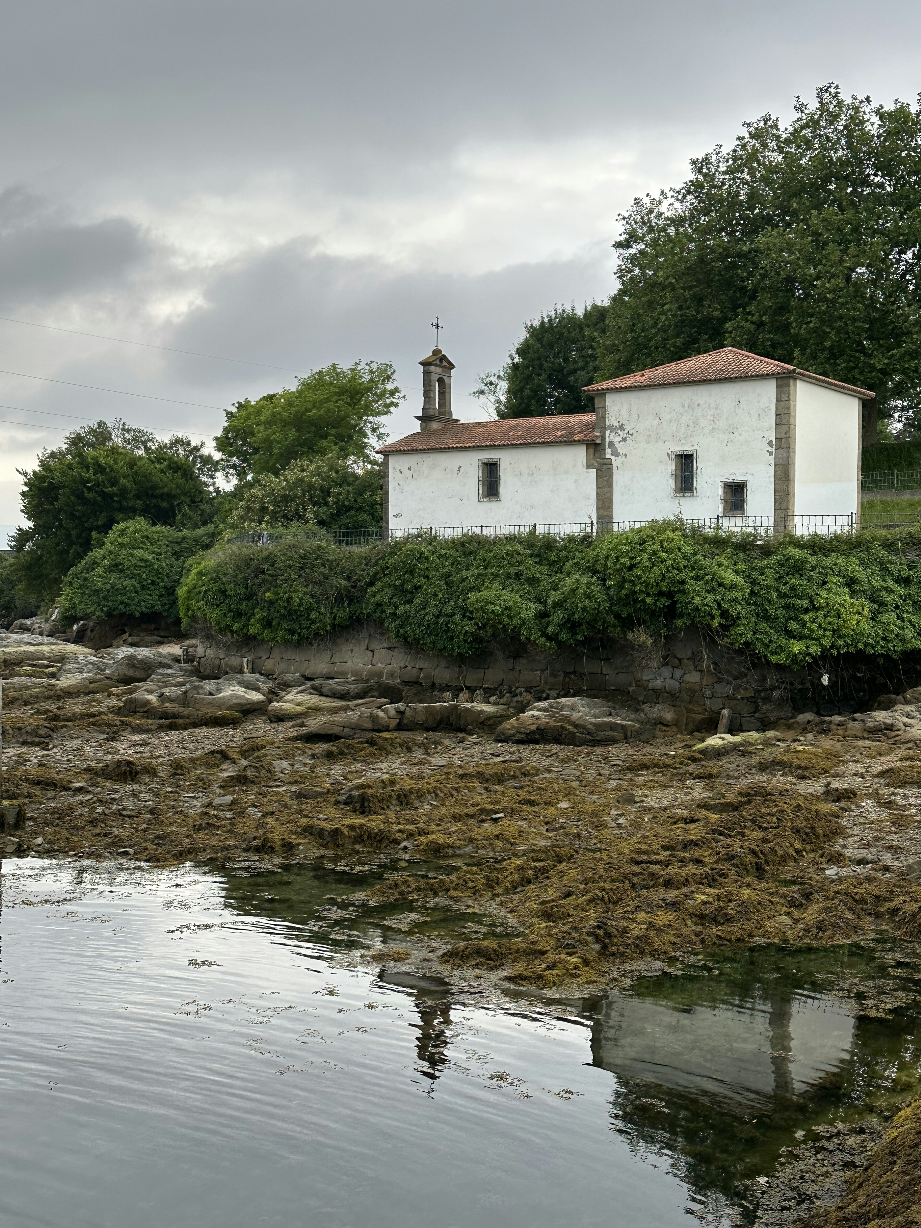 Seaside Chapel on a Rocky Shore Beneath a Brooding Sky