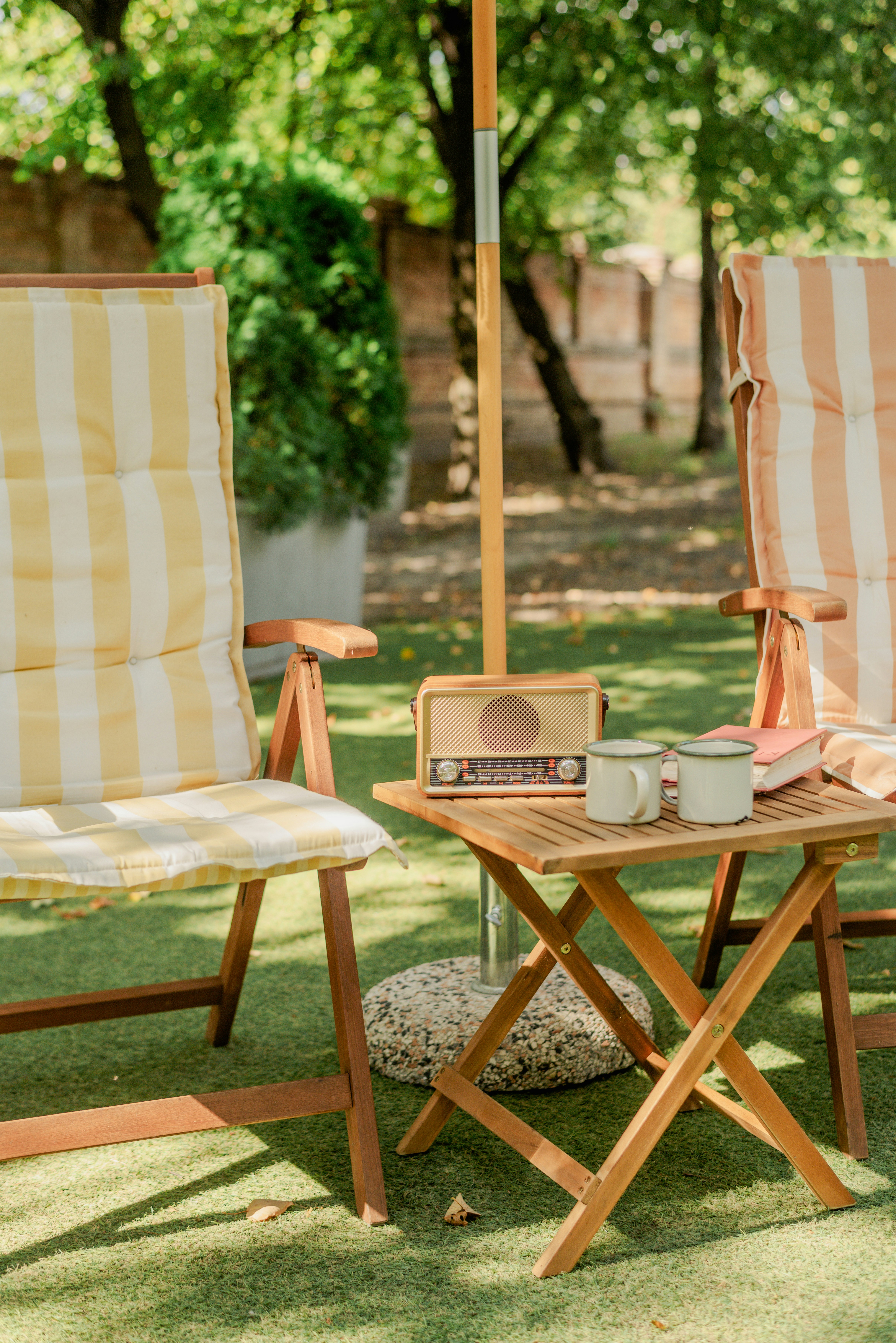 Sunlit courtyard set with striped chairs and vintage radio