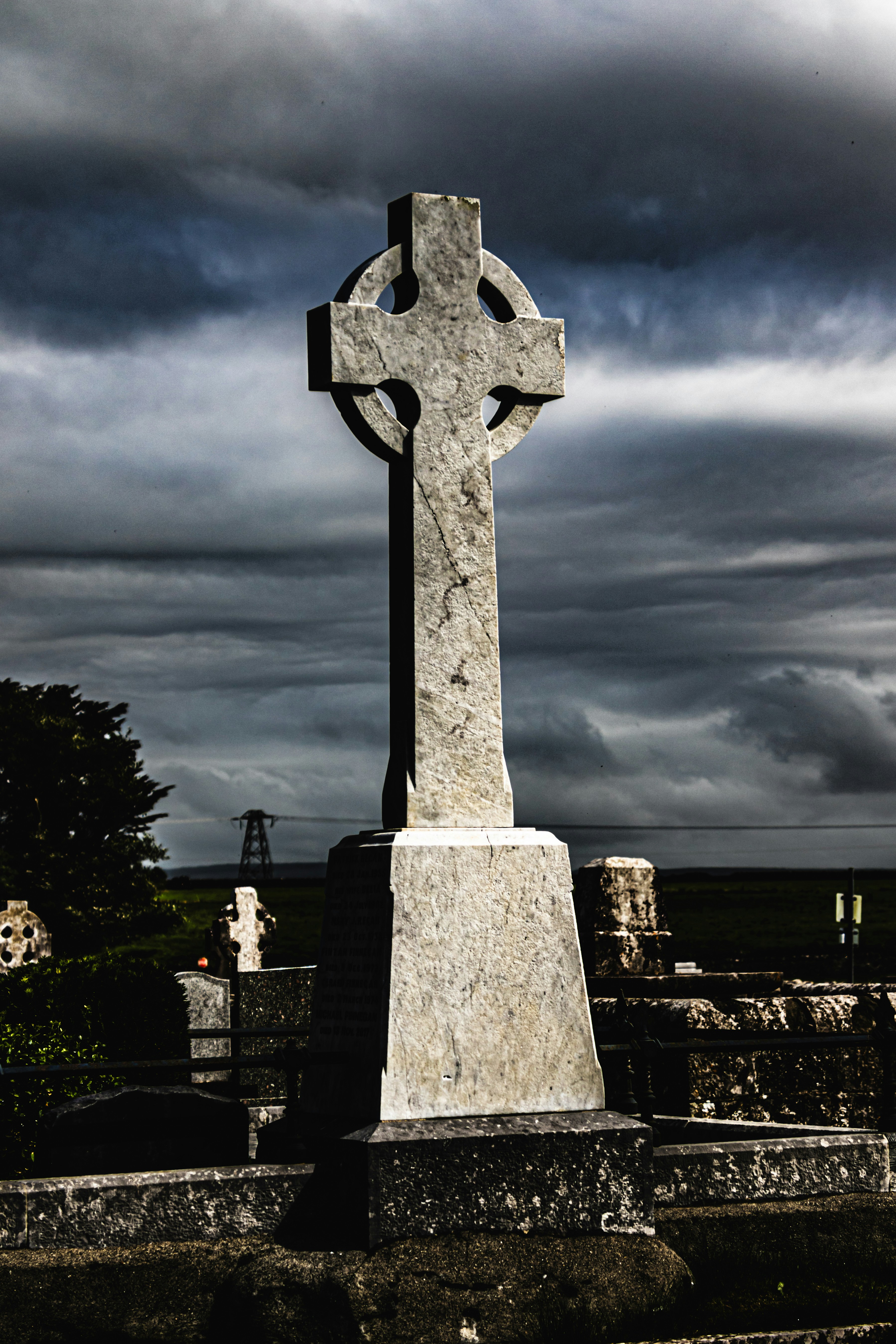 A large stone cross sitting in the middle of a cemetery photo – Free ...