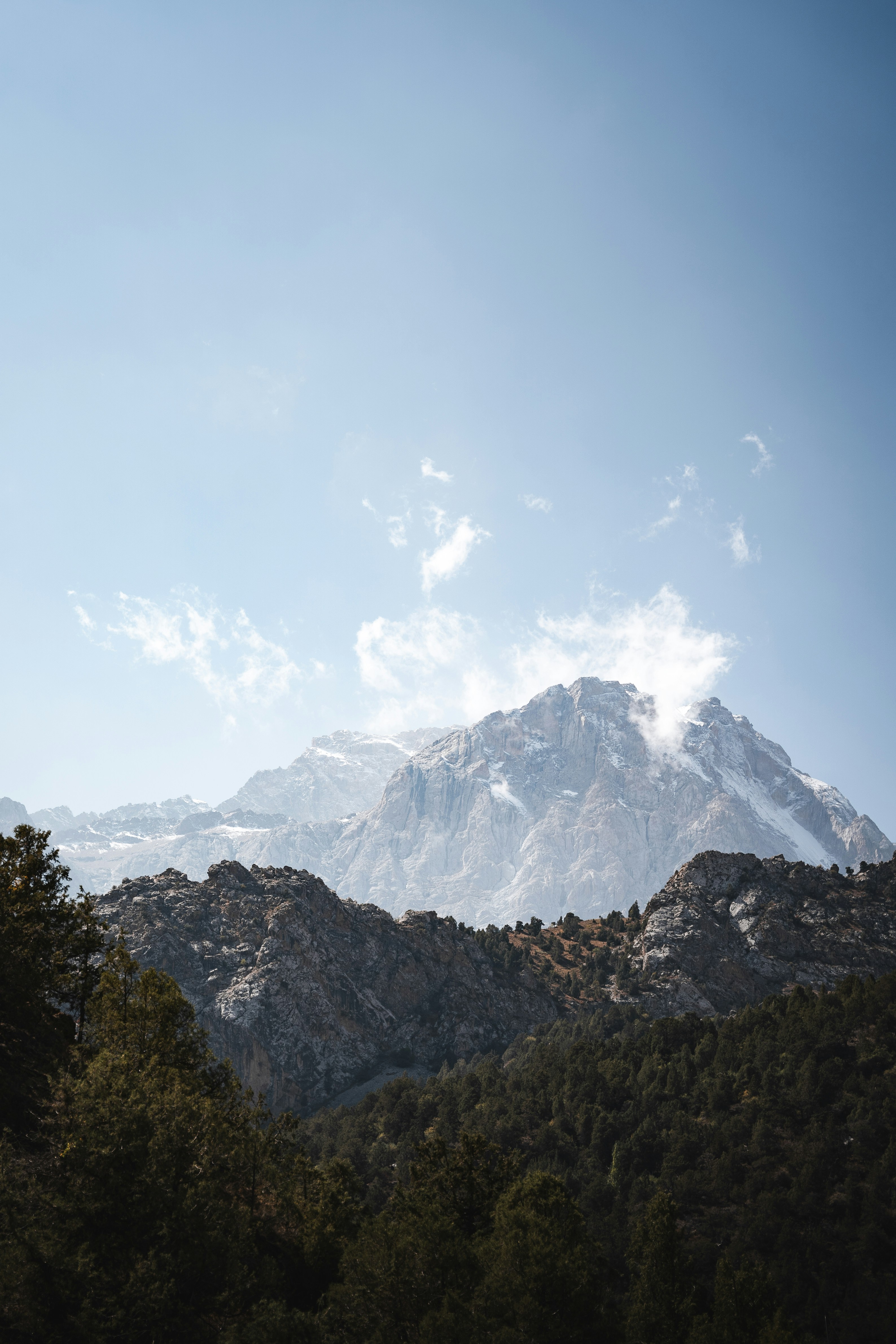 A view of a mountain range with trees in the foreground photo – Free ...