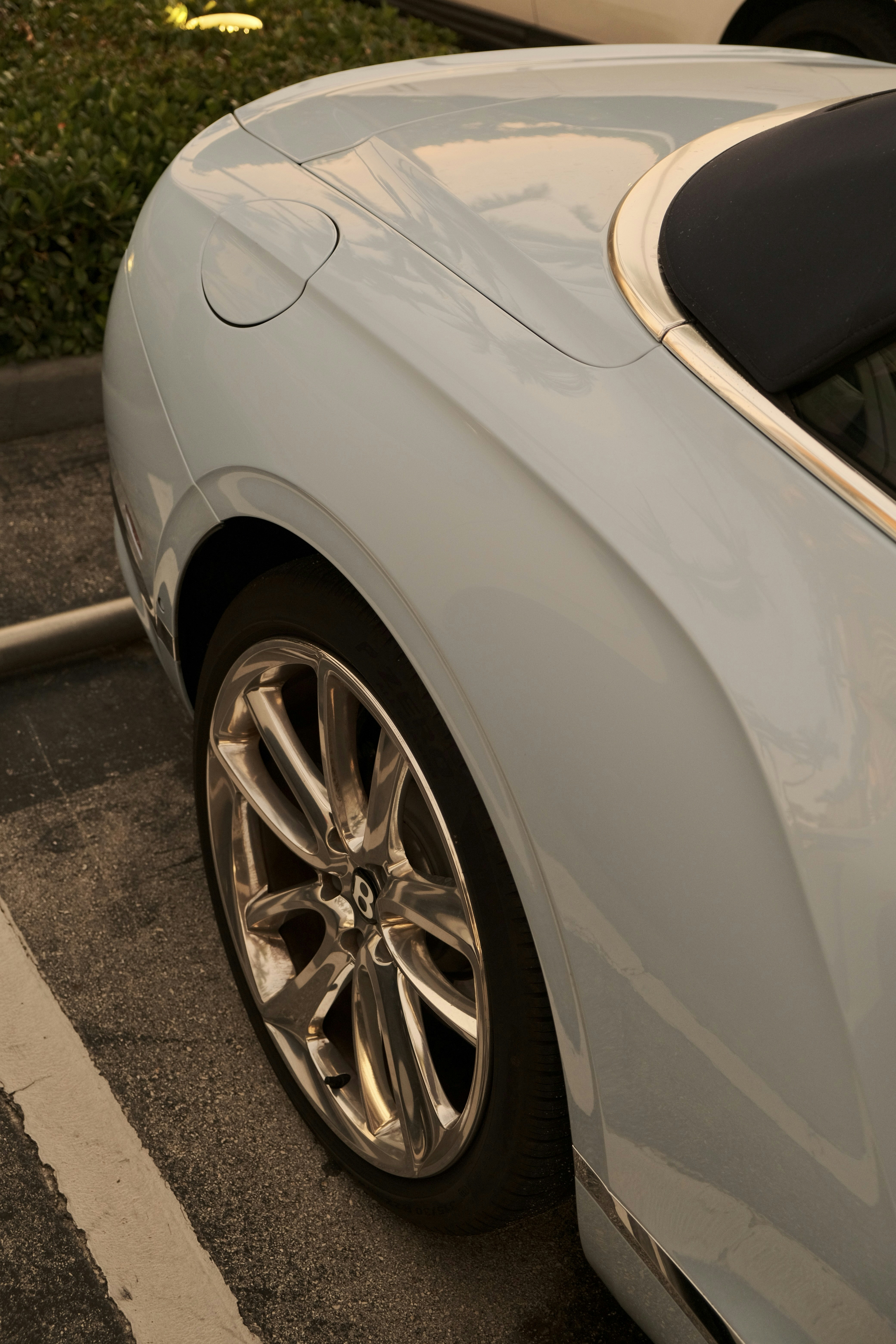 Chrome-Spoked Wheel and Satin Curves on a White Luxury Coupe