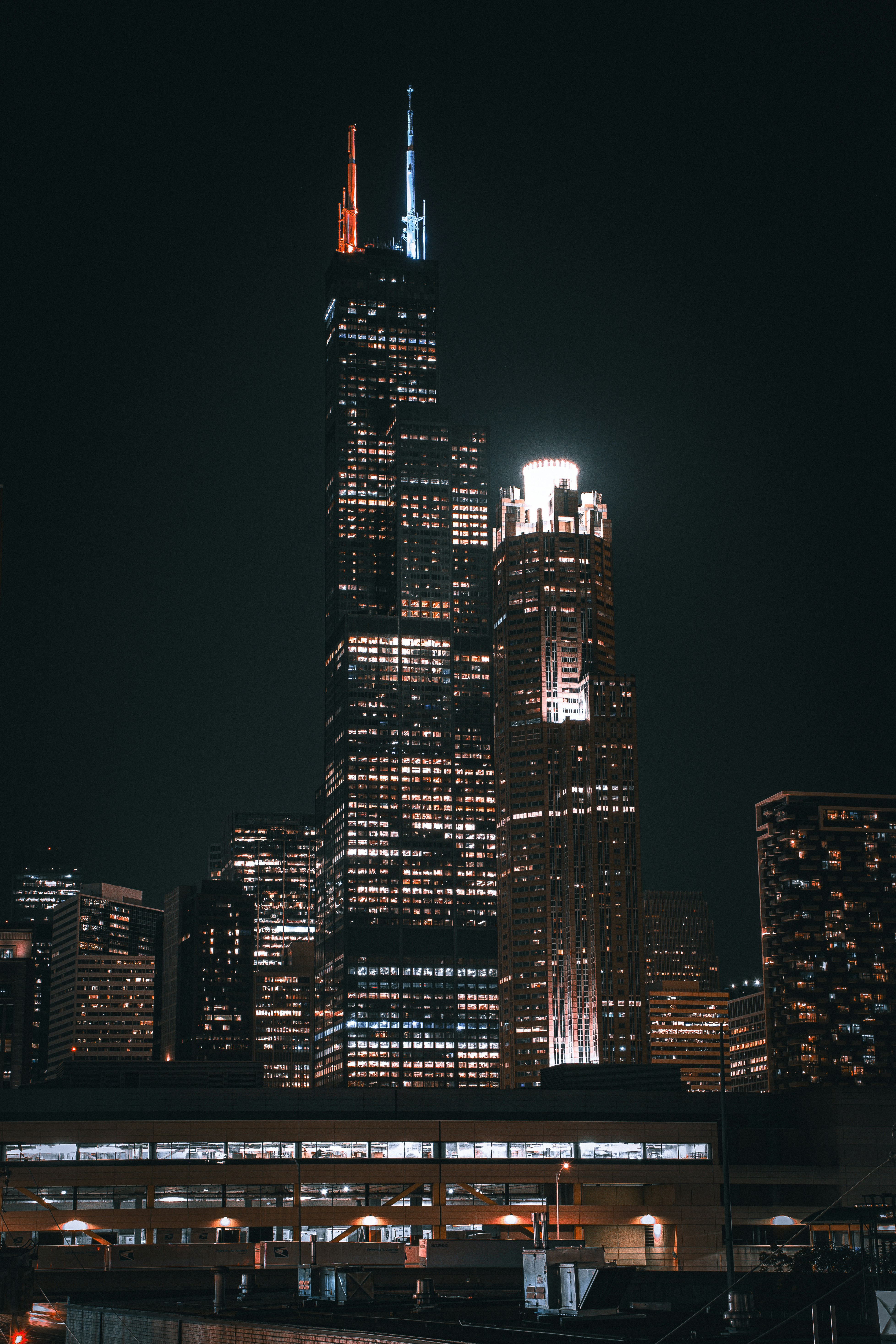 A very tall building in a big city at night photo – Free Architecture ...