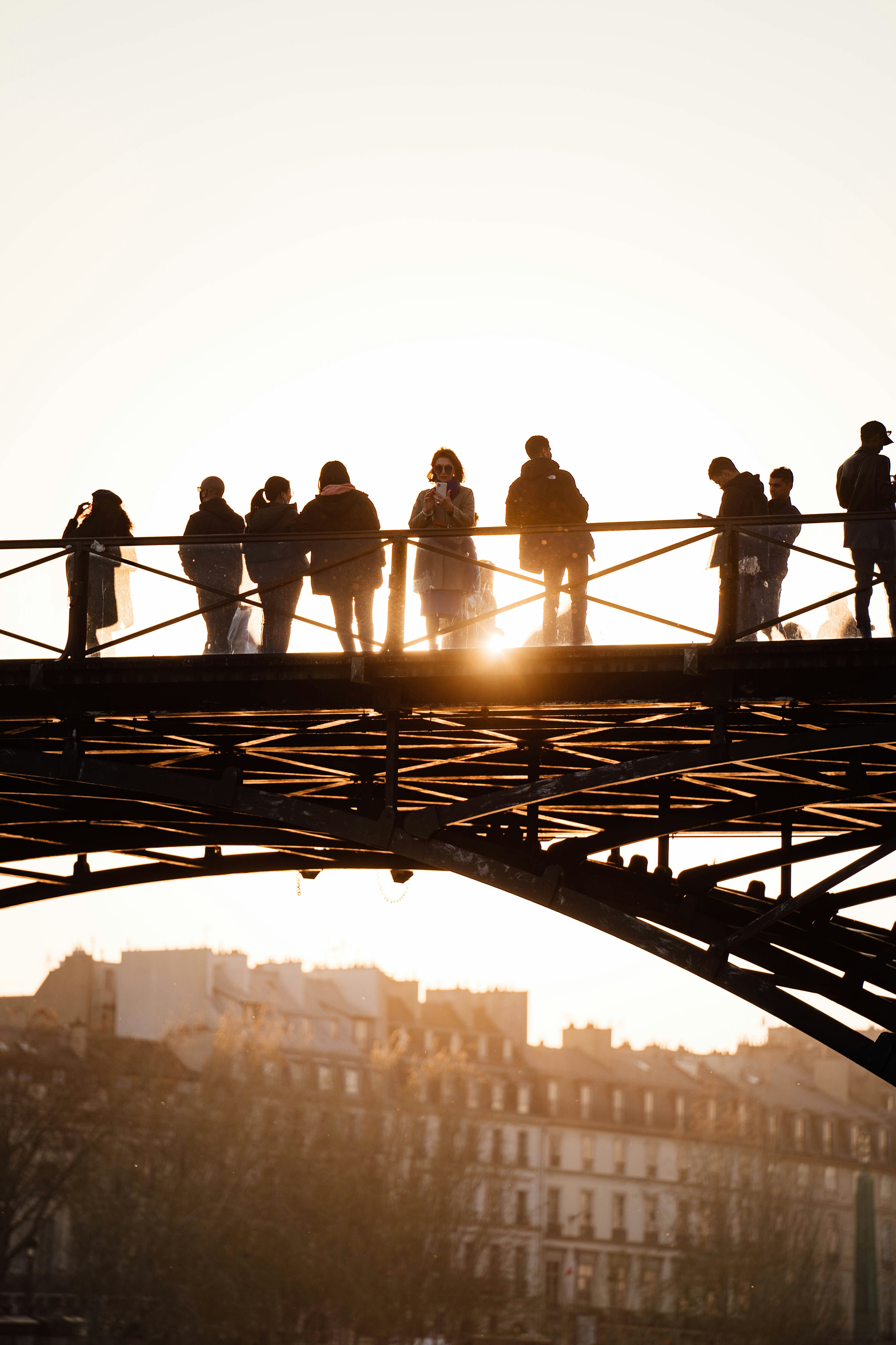 A group of people standing on top of a bridge photo – Free Man Image on ...