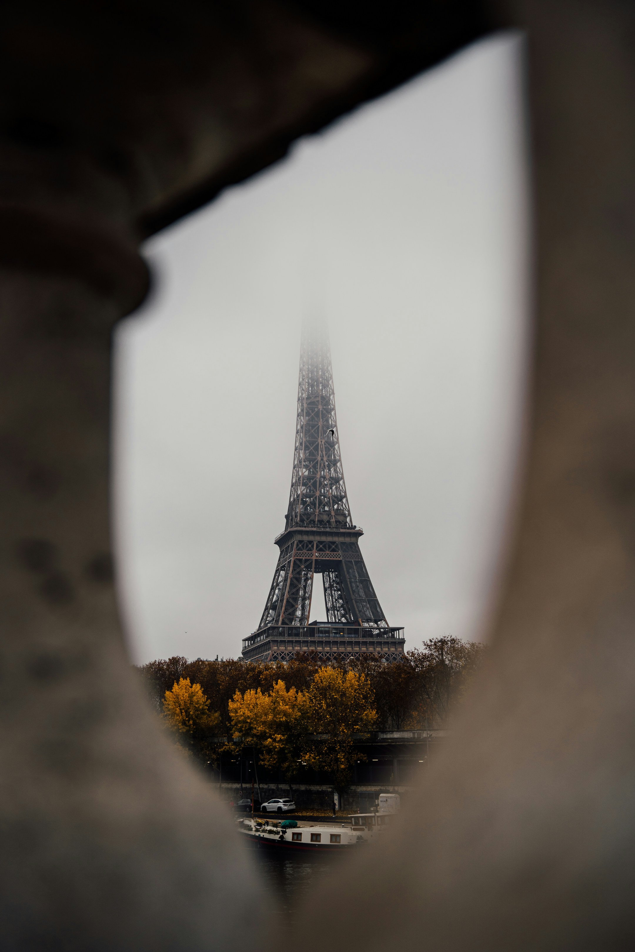 Eiffel Tower Through a Stone Iris: Autumn Fog Framing