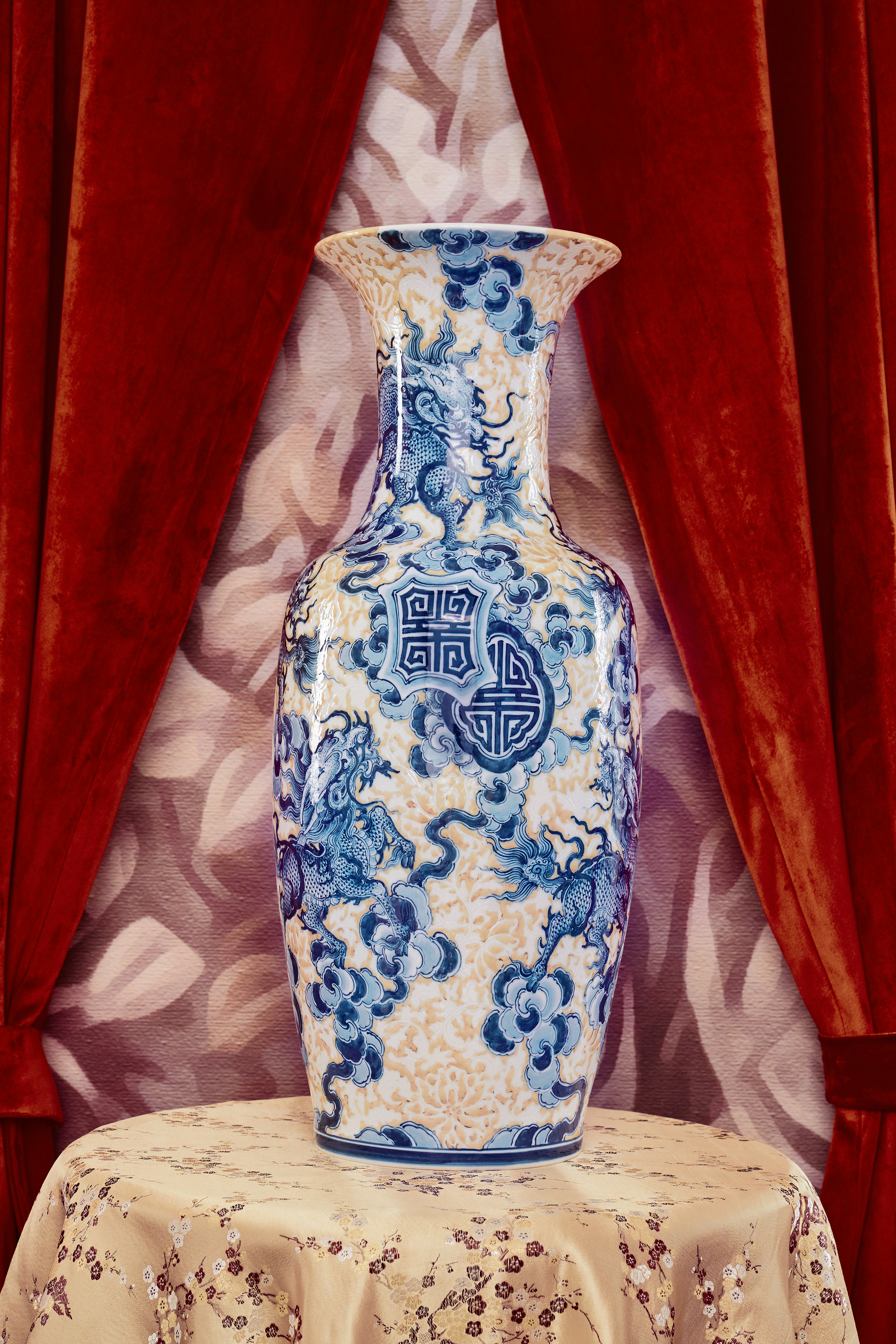Azure Porcelain Vase Framed by Crimson Velvet Drapes