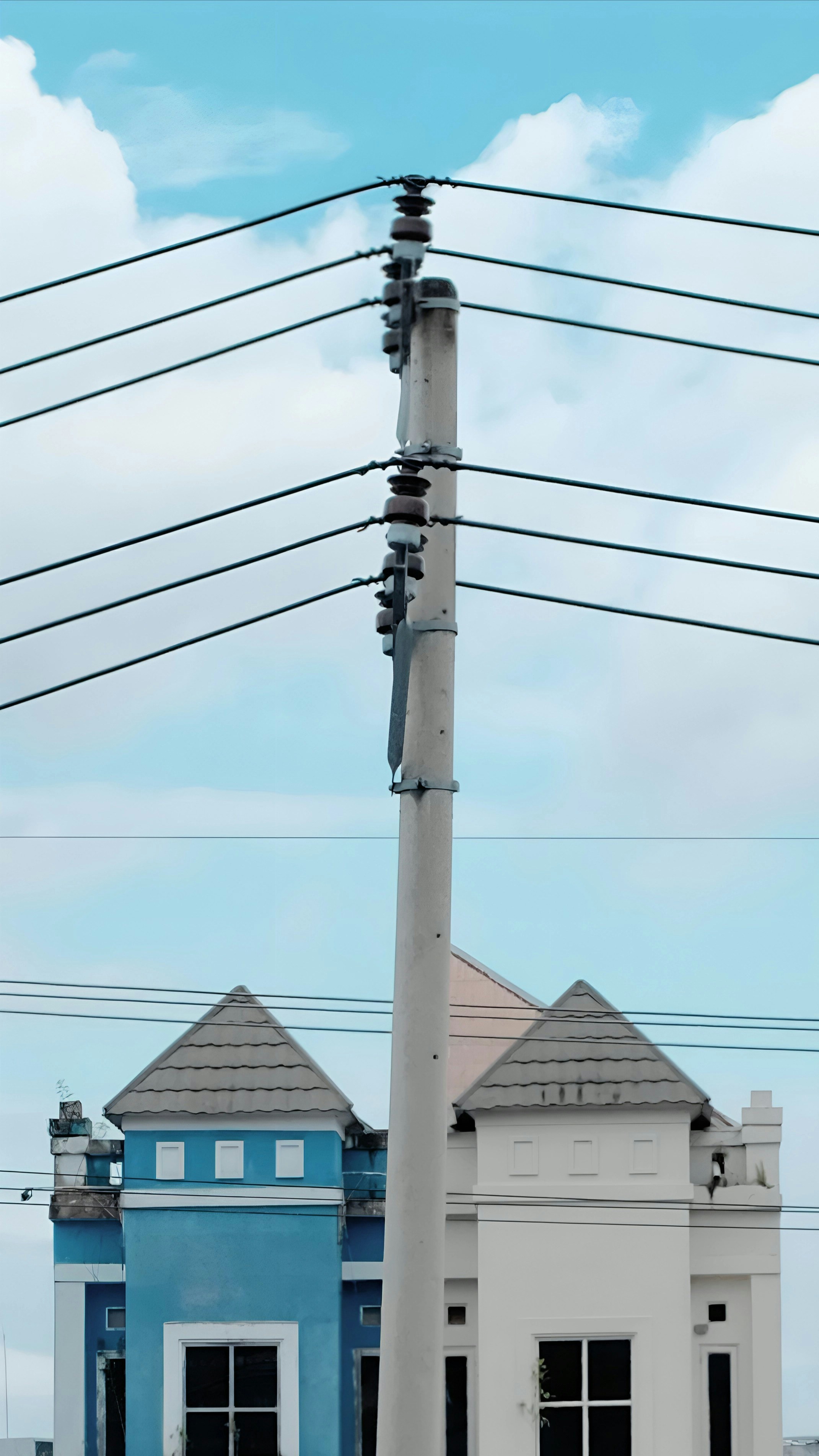 A telephone pole in front of a blue and white building