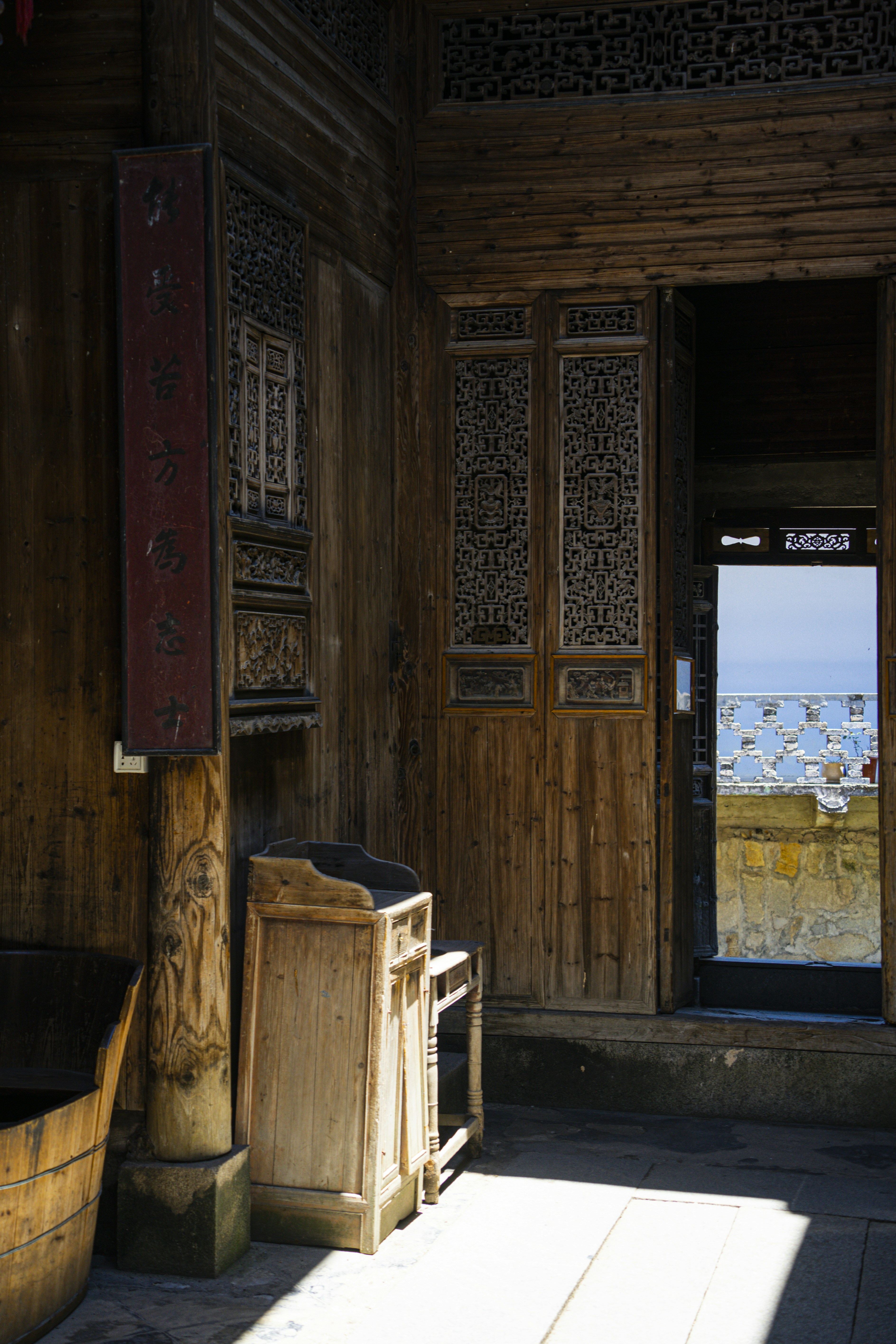 Sunlit Threshold: Ocean Framed by Hand-Carved Woodwork