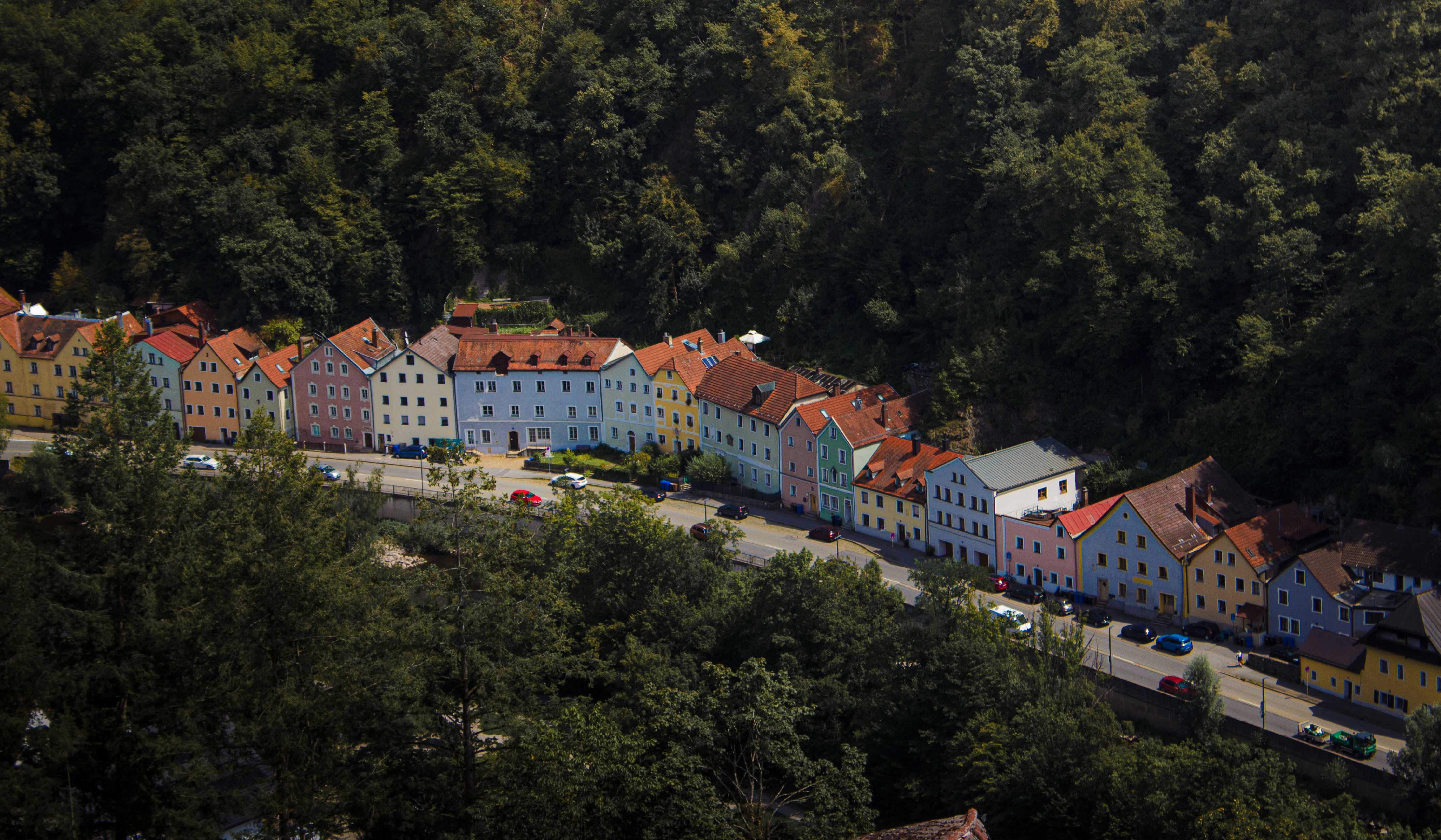 Colorful houses nestled along a tree-lined hillside under soft, natural light.