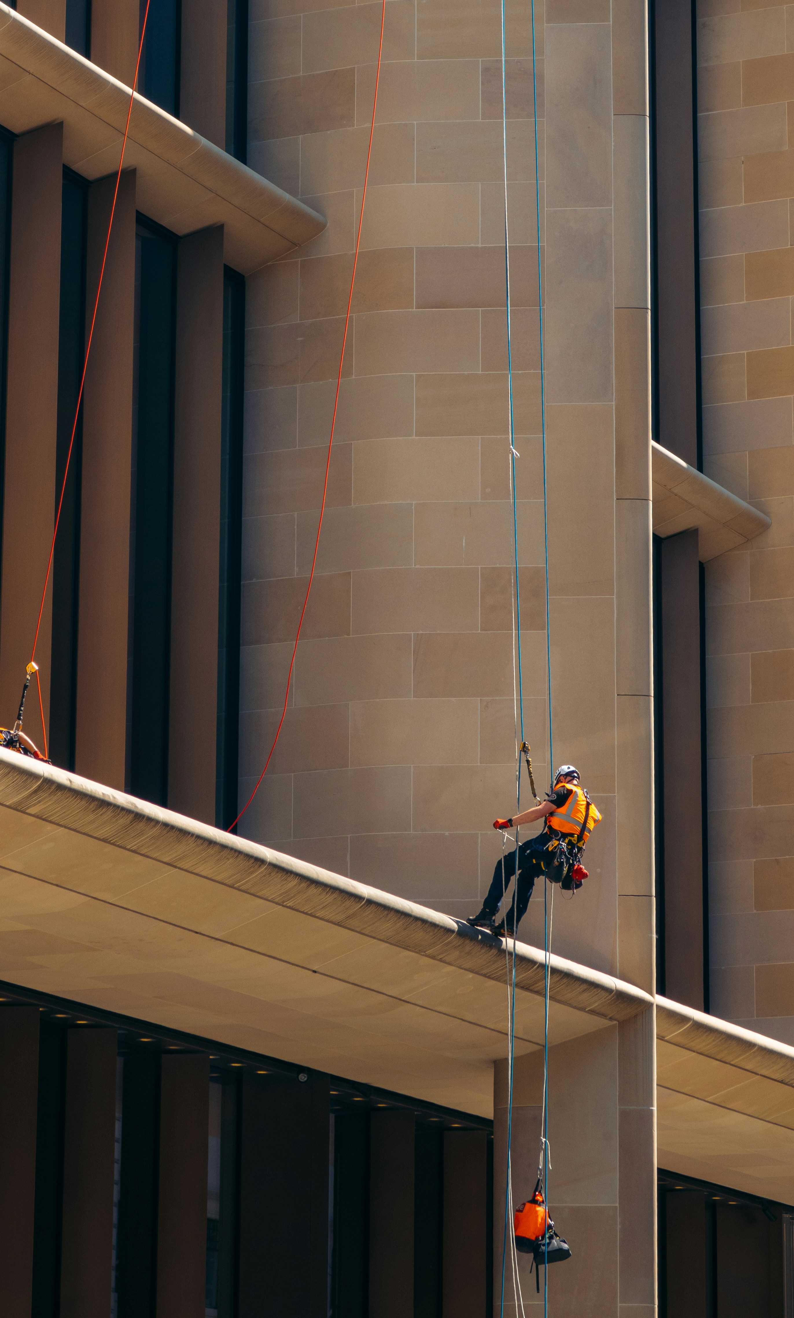 A man on a rope on the side of a building photo – Free London Image on ...