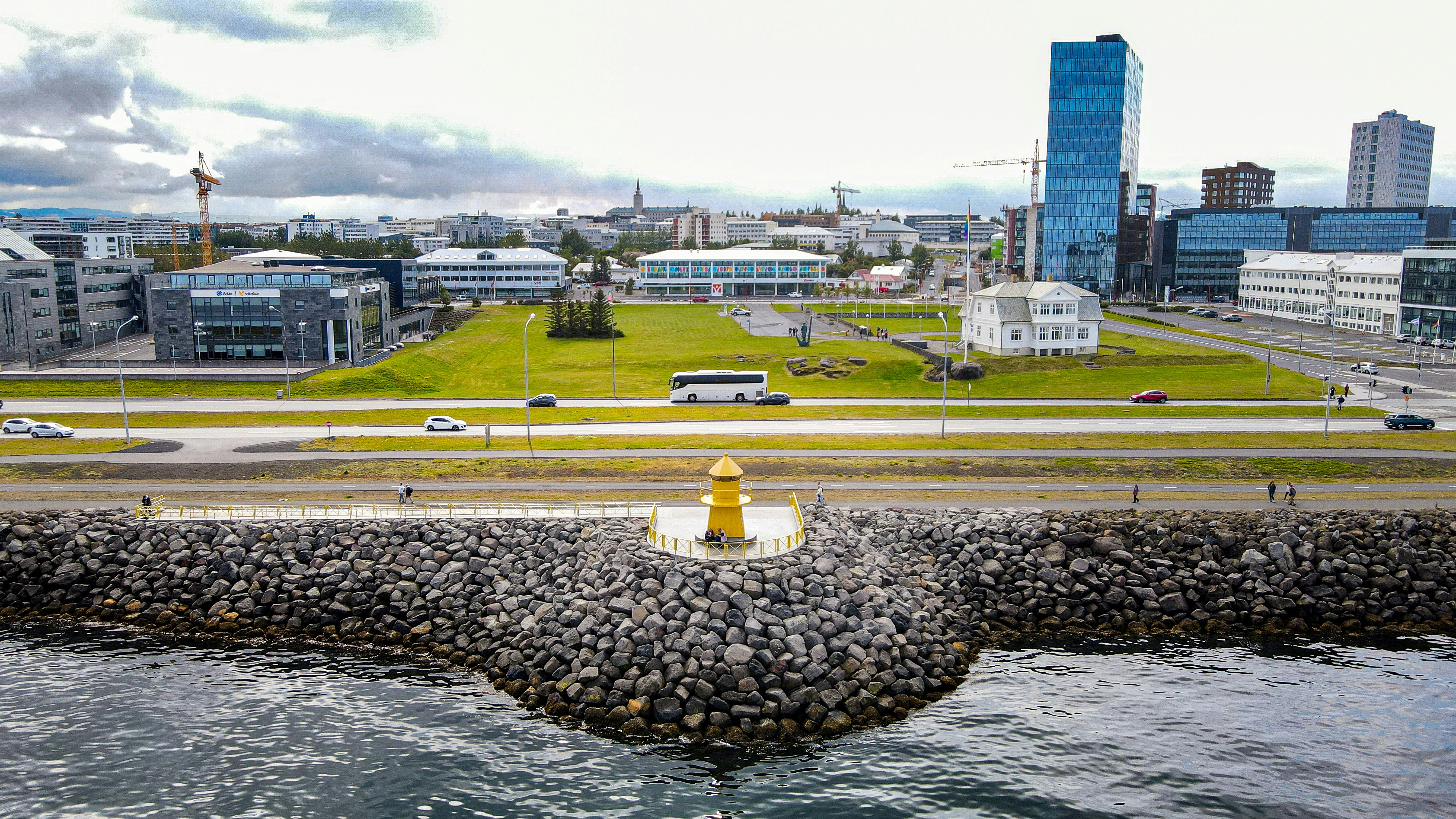 Amber Beacon on the Breakwater Framing a Glassy City Seascape