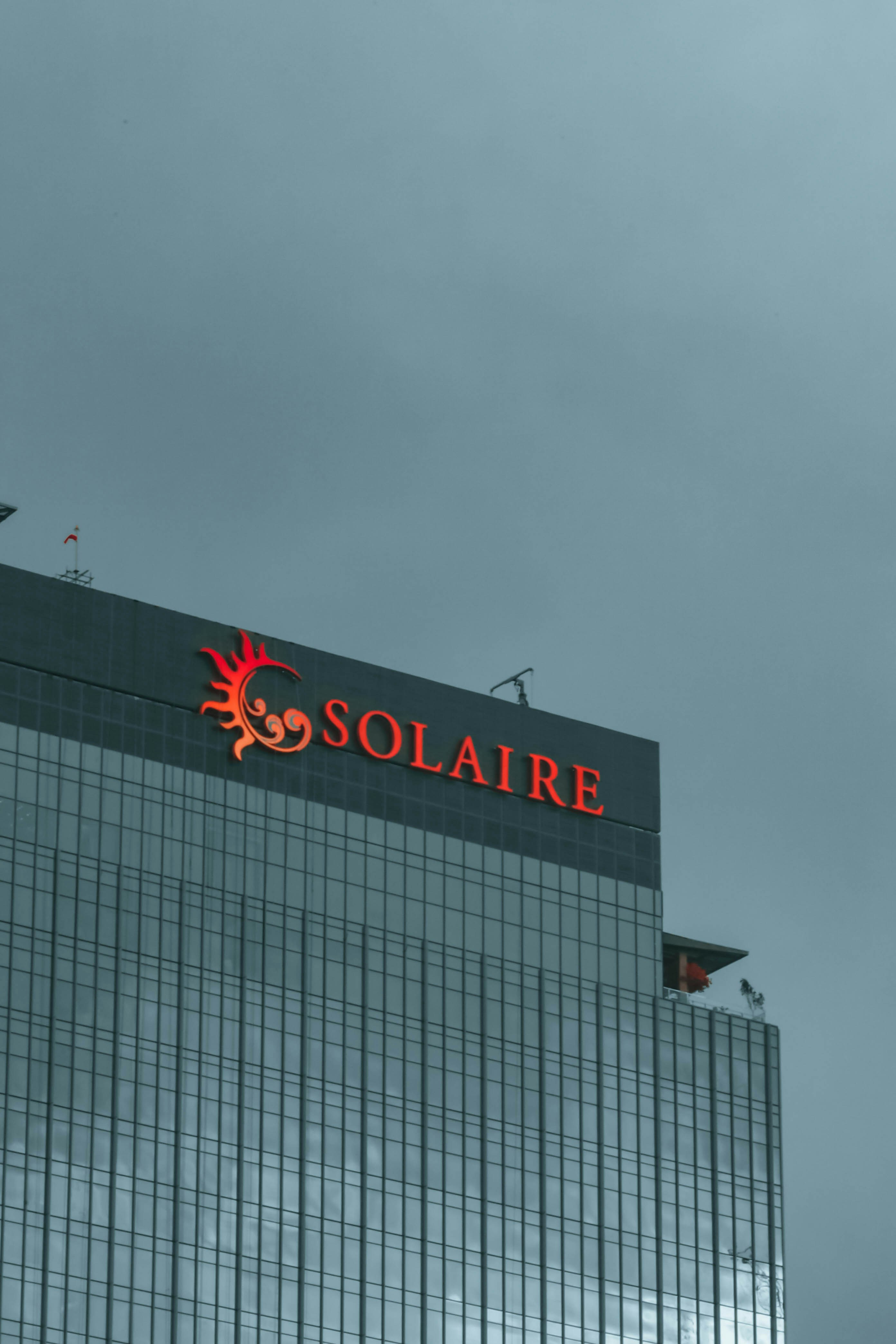 A tall building with a red solaire sign on it photo – Free Street ...