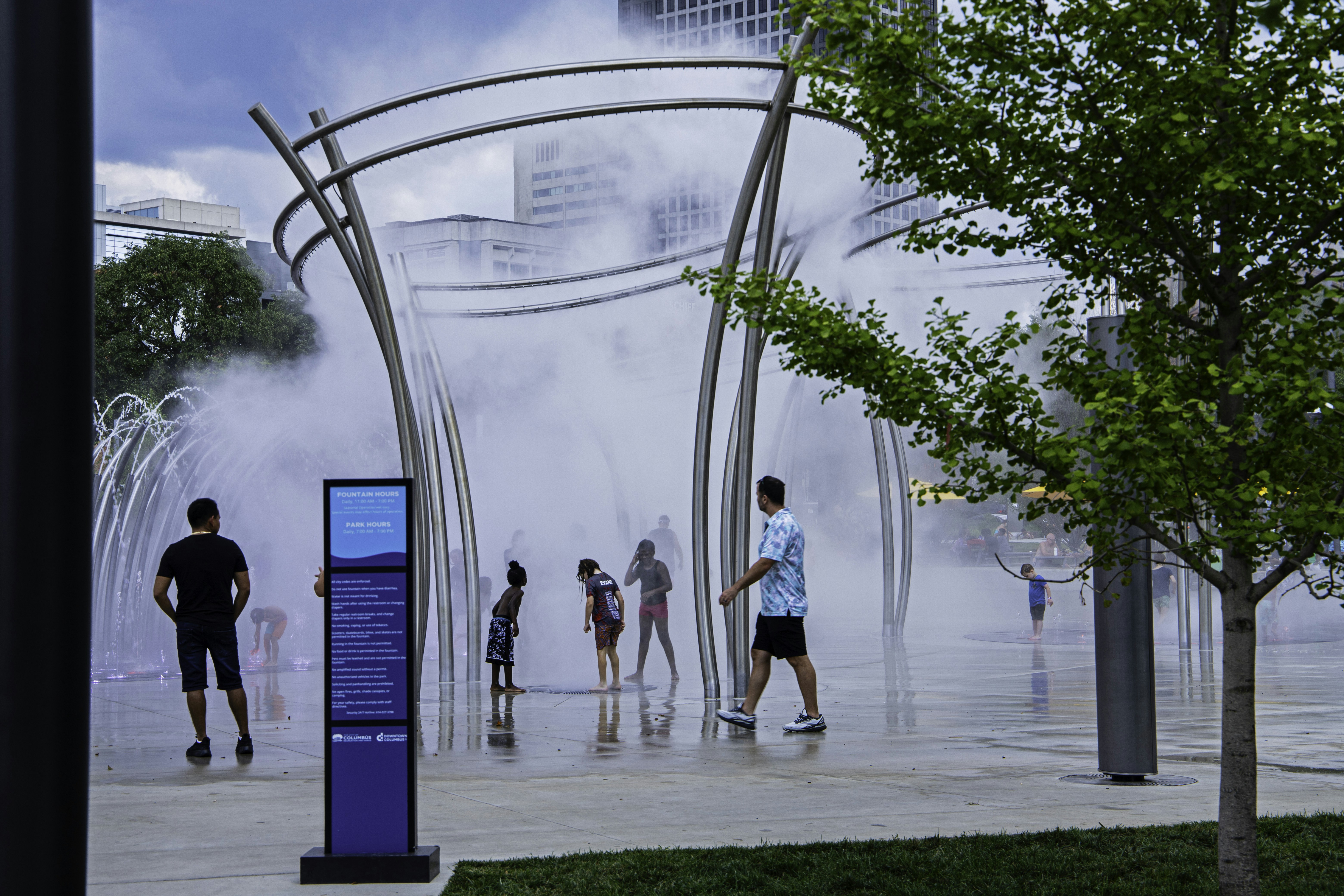 Mist Under Steel Arches: Pedestrians in a Fog-Wreathed Plaza