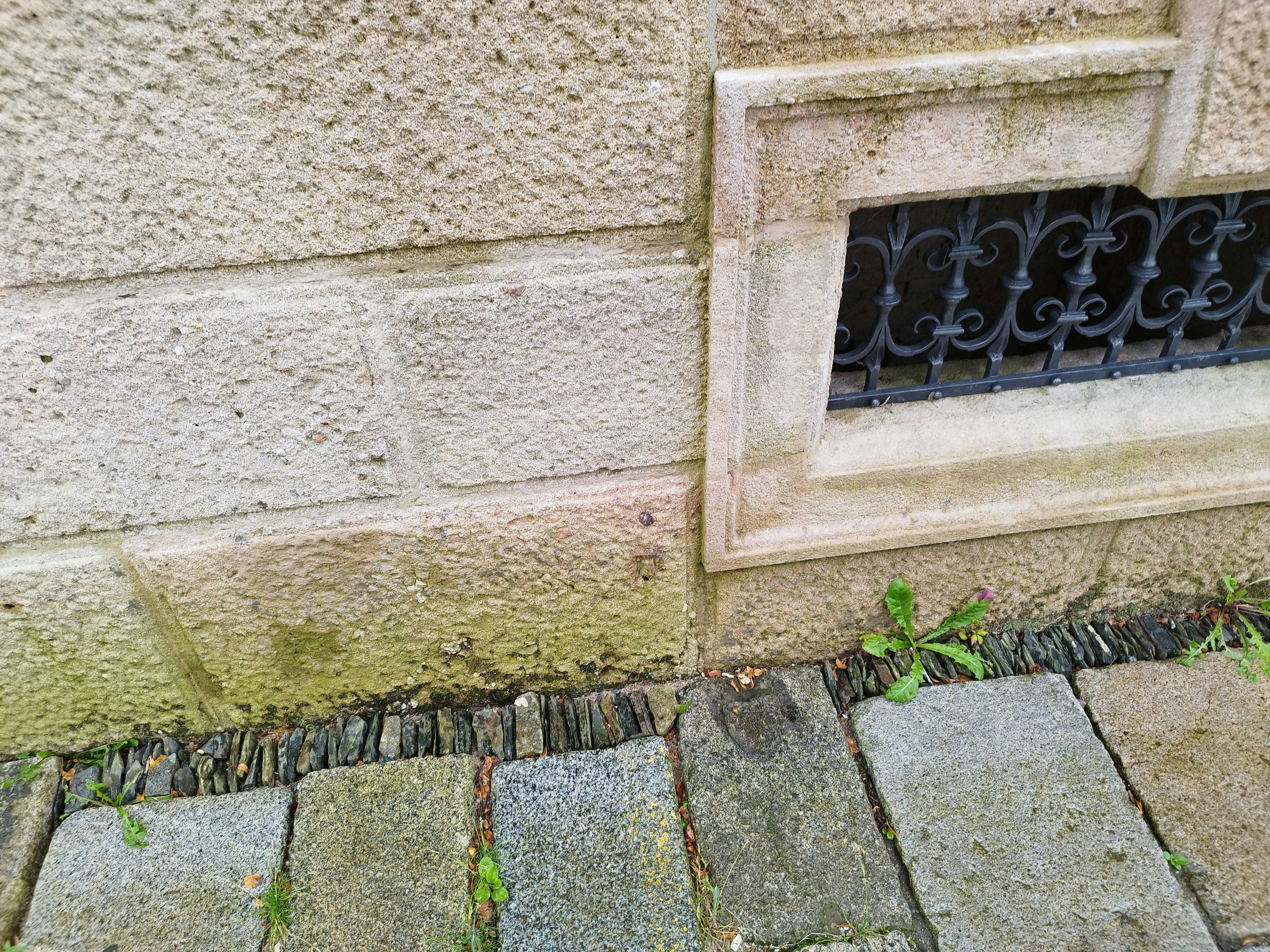 A brick sidewalk with a small window on the side of it photo – Free ...