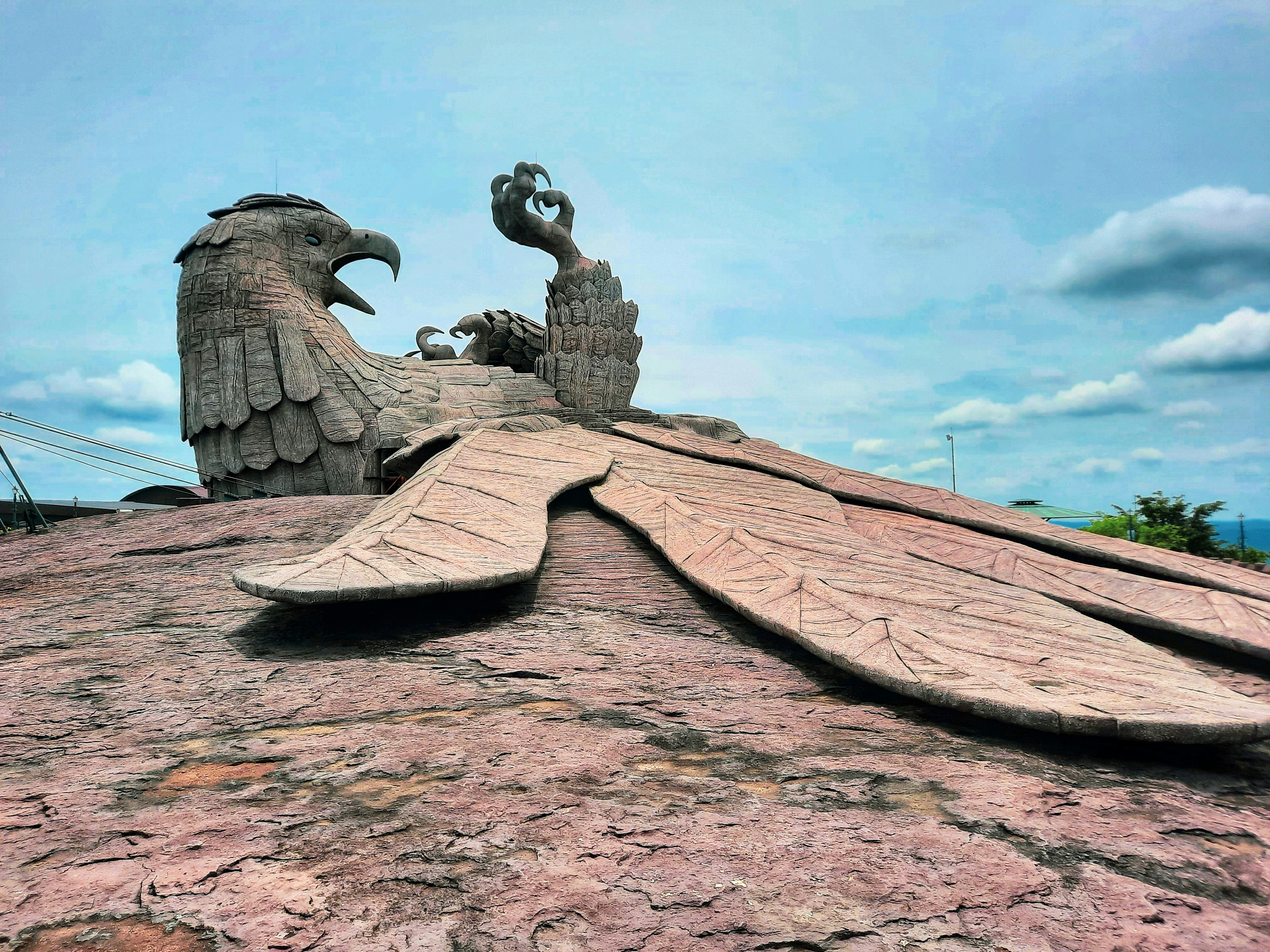A large bird statue sitting on top of a rock photo – Free Art Image on ...