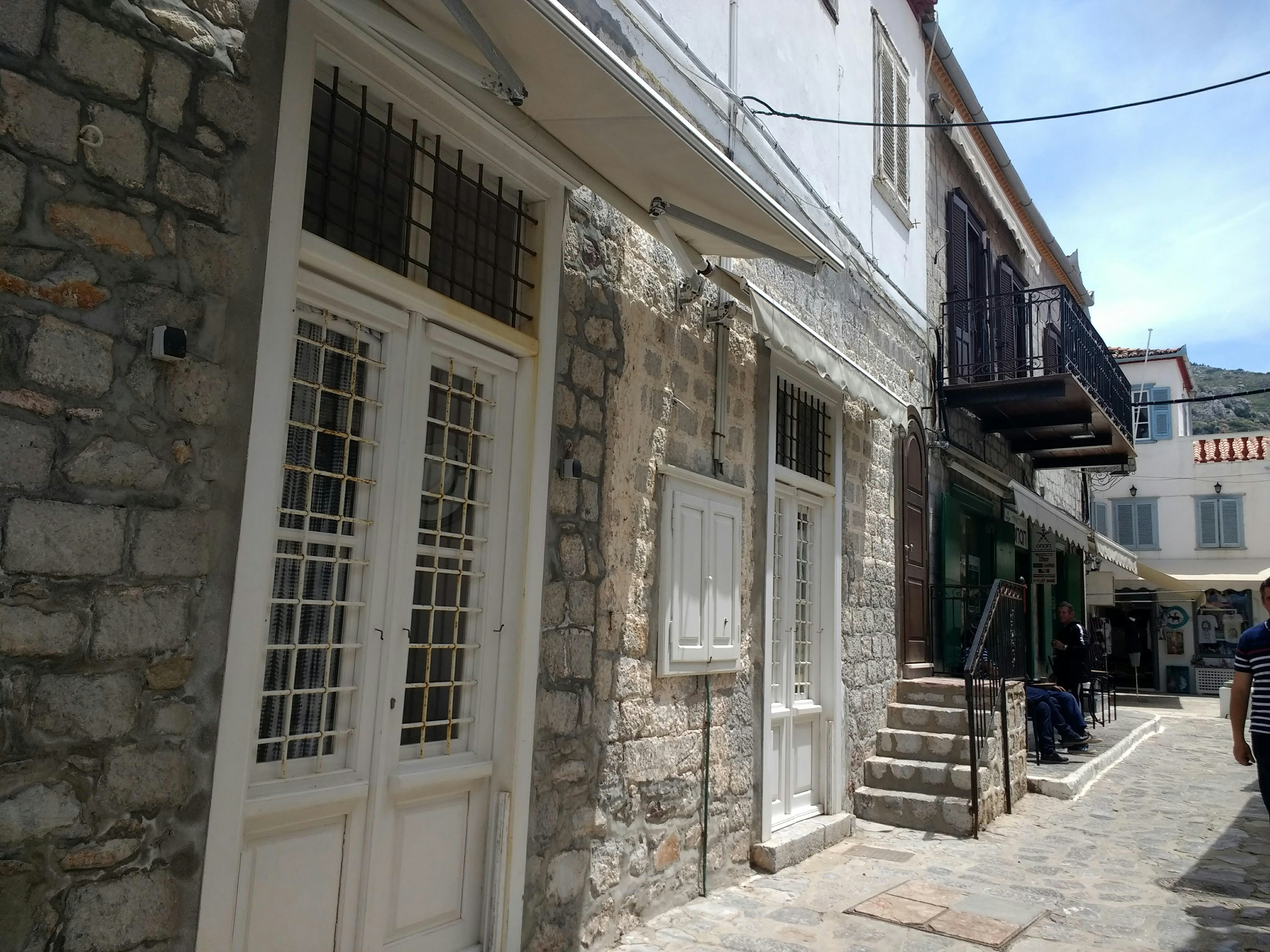 Sunlit Stone Lane: White Doors and Aged Facades on a Mediterranean Street