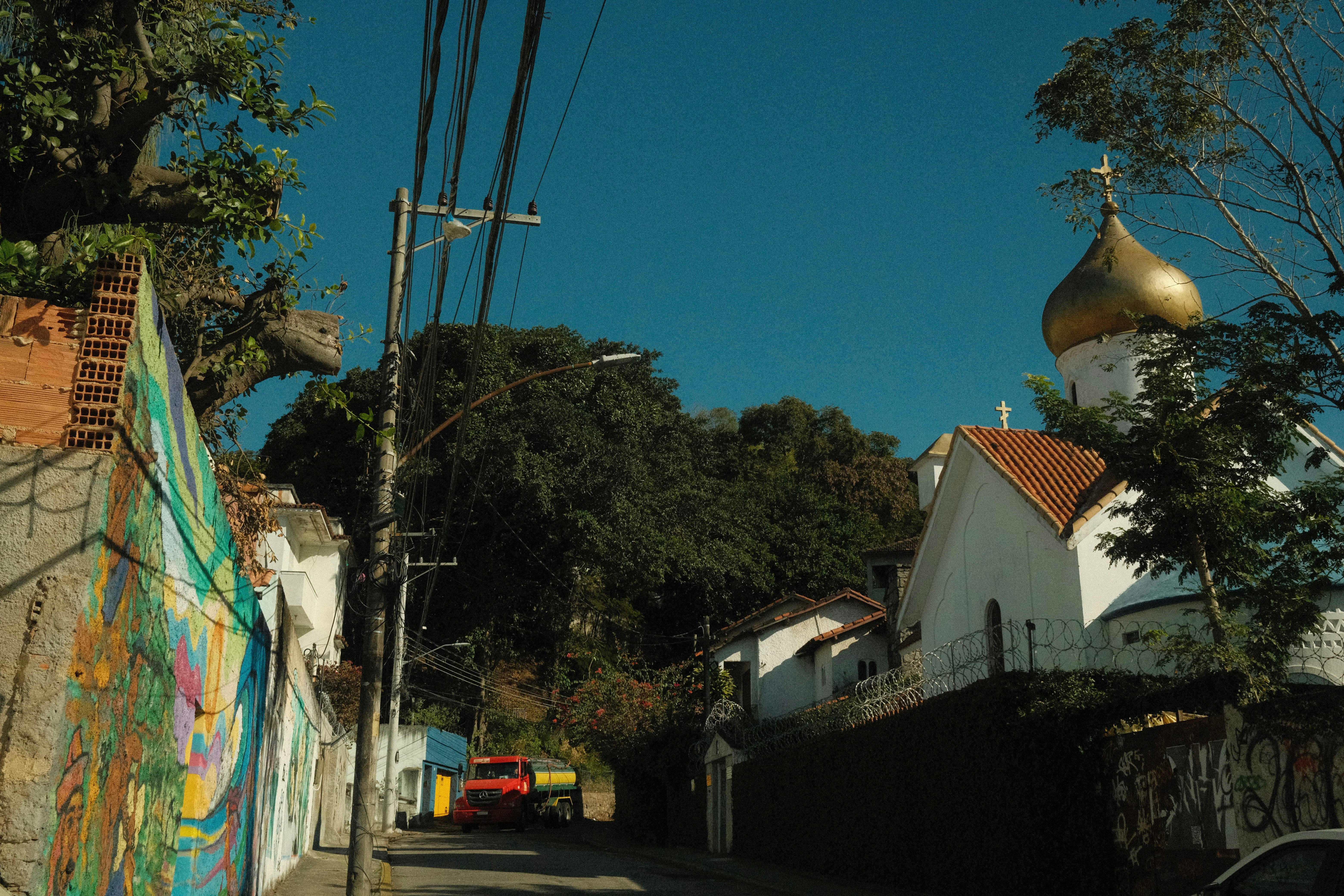Alleyway Confluence: Murals, a Red Truck, and a Golden Dome