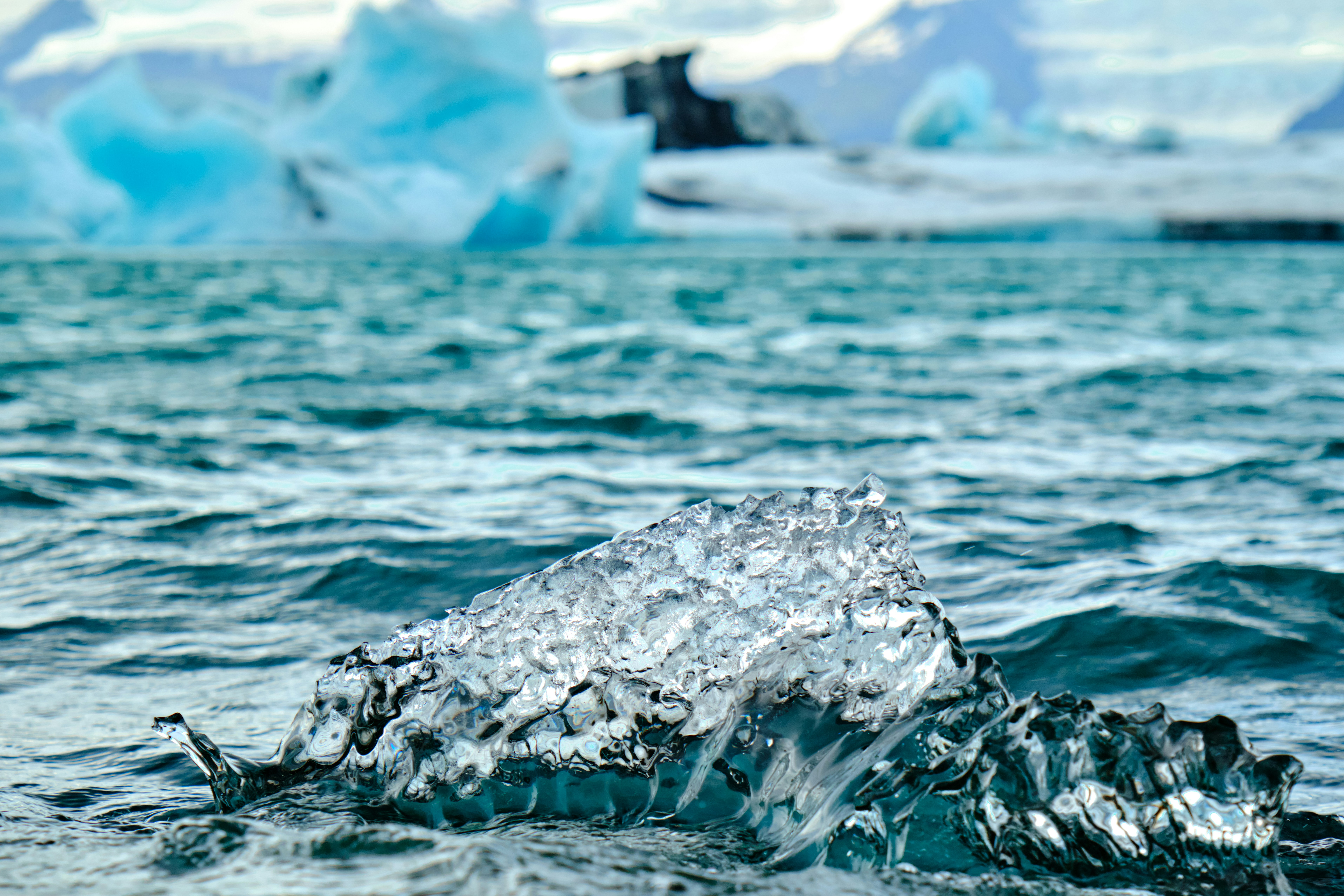 Turquoise Crest: A Glacial Fragment Rises Over a Quiet Sea