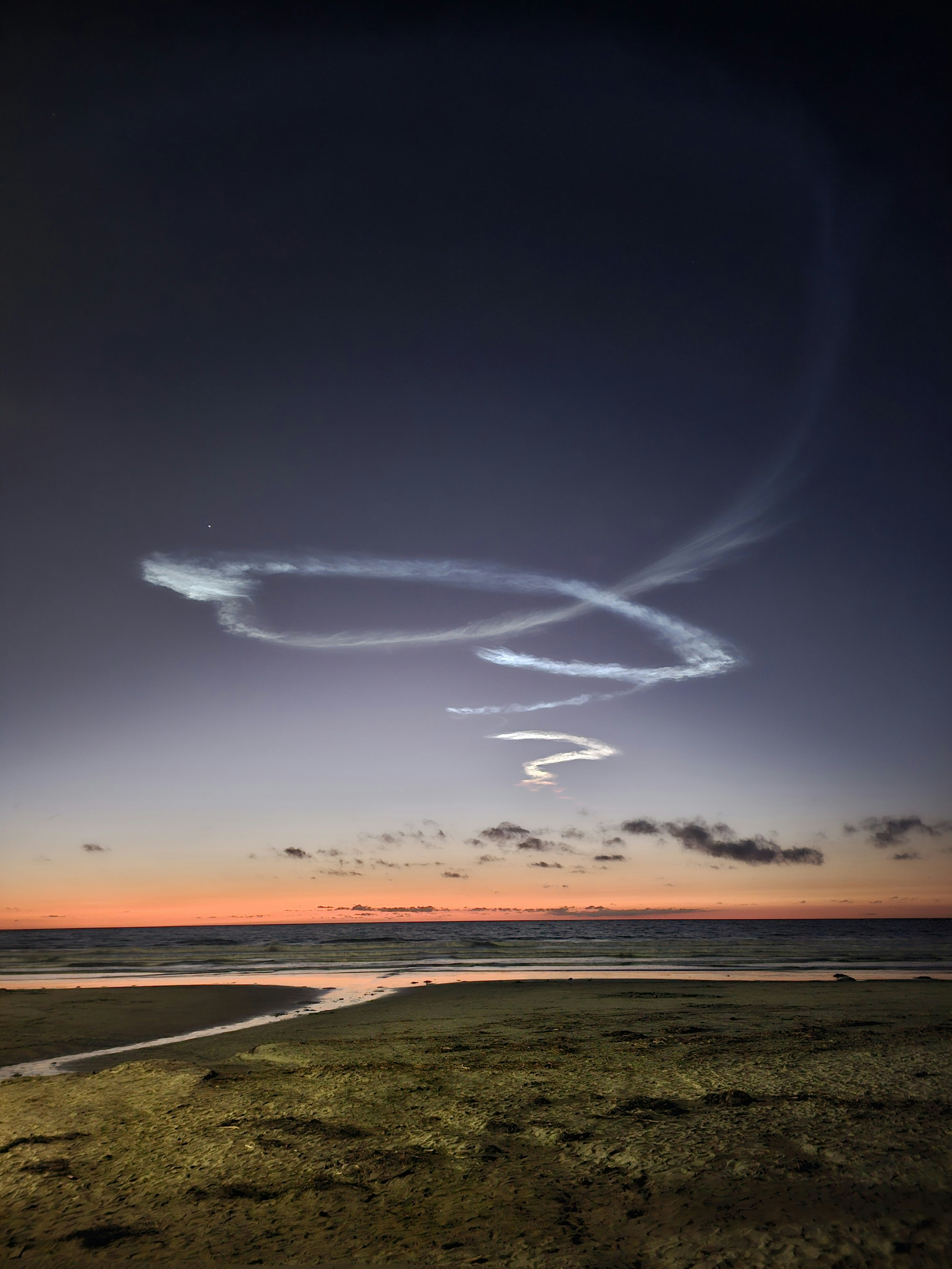 Twilight Spiral Over a Quiet Beach at Dusk