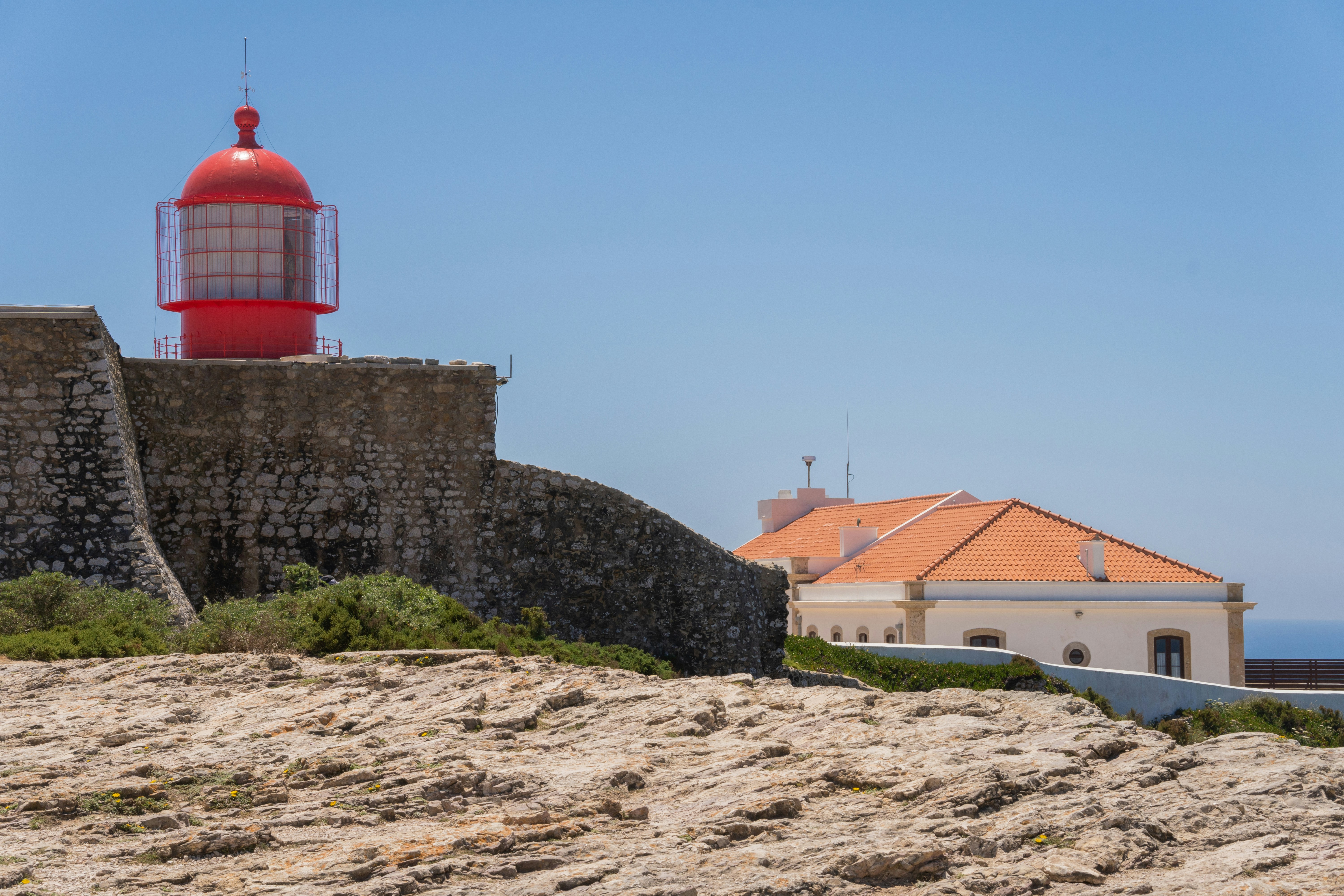 Crimson Lighthouse on a Weathered Granite Bastion
