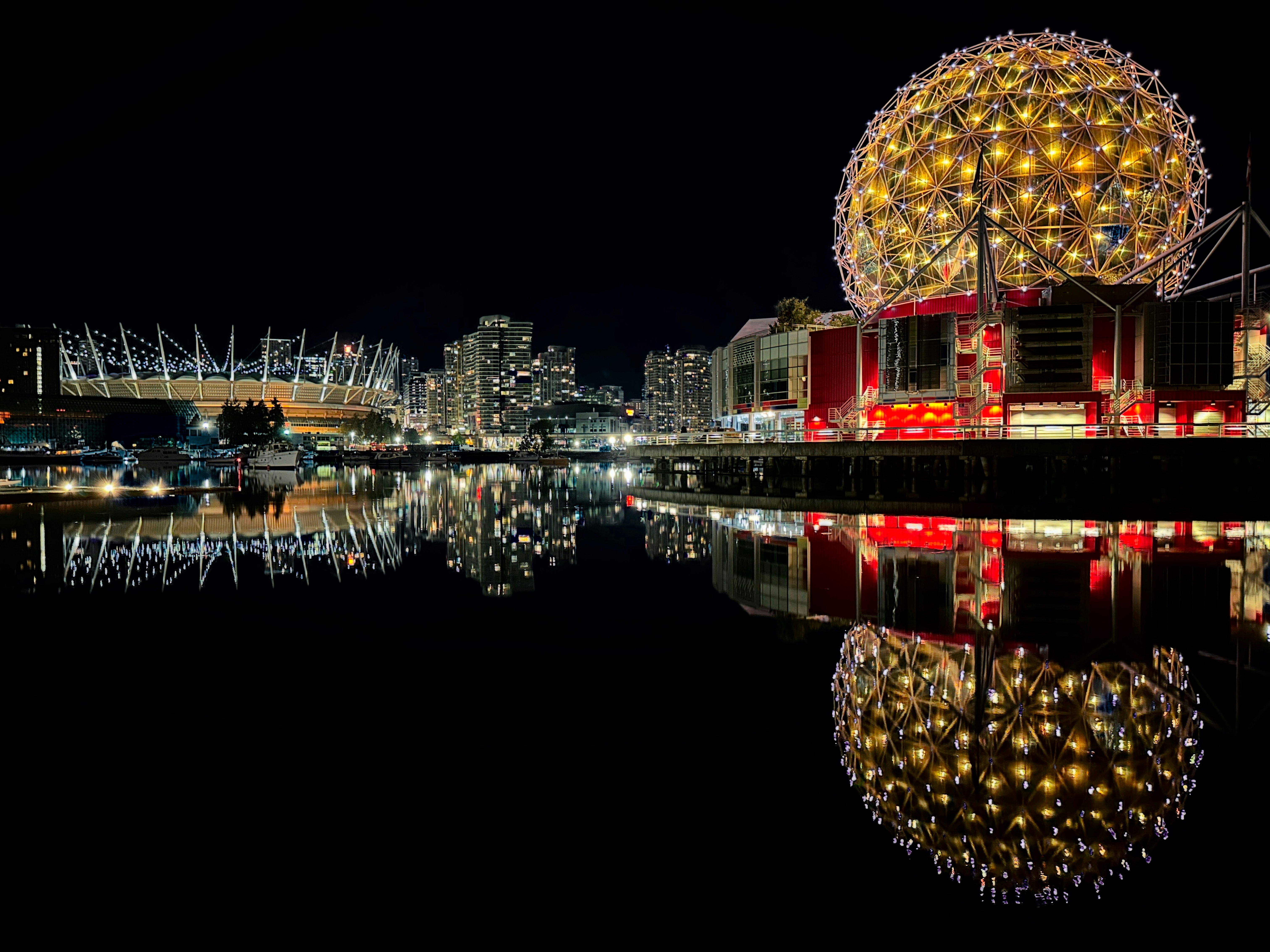 Geodesic Sphere in Neon Night: City Lights Reflected on Calm Water