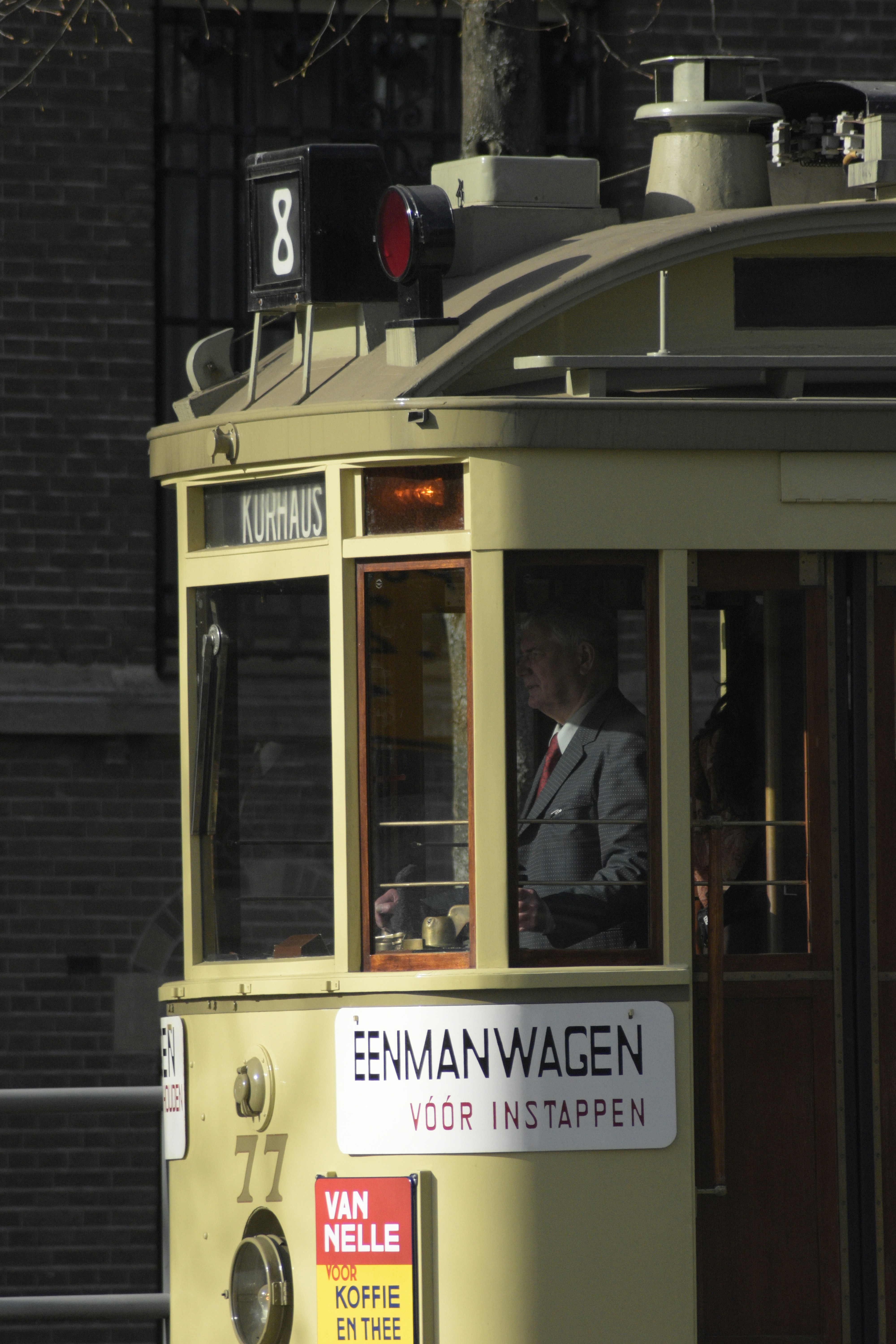Cream-Yellow Tram at the Edge of the City: A Conductor in a Vintage Carriage