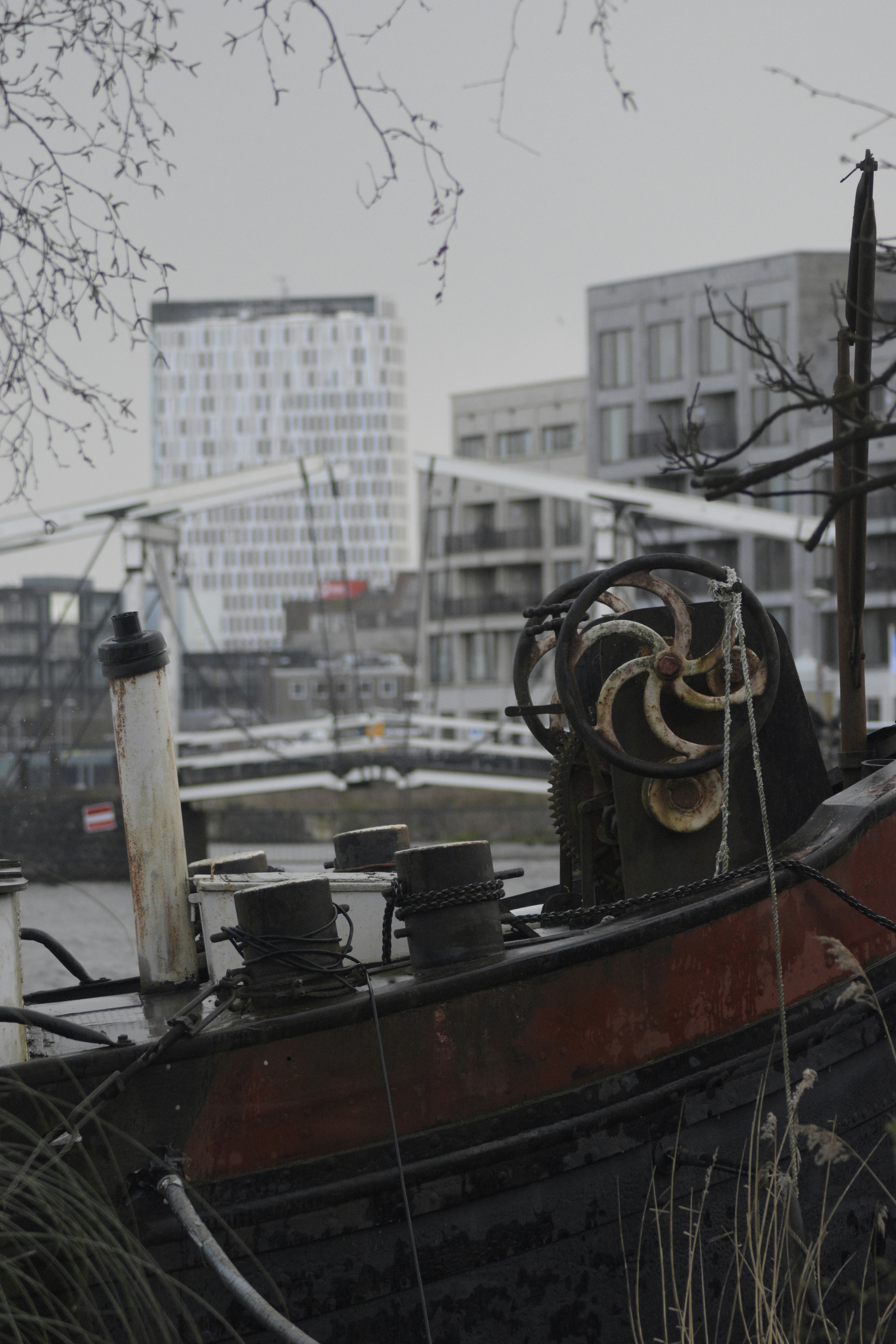 Rusted Vessel Against a Glassy Cityscape