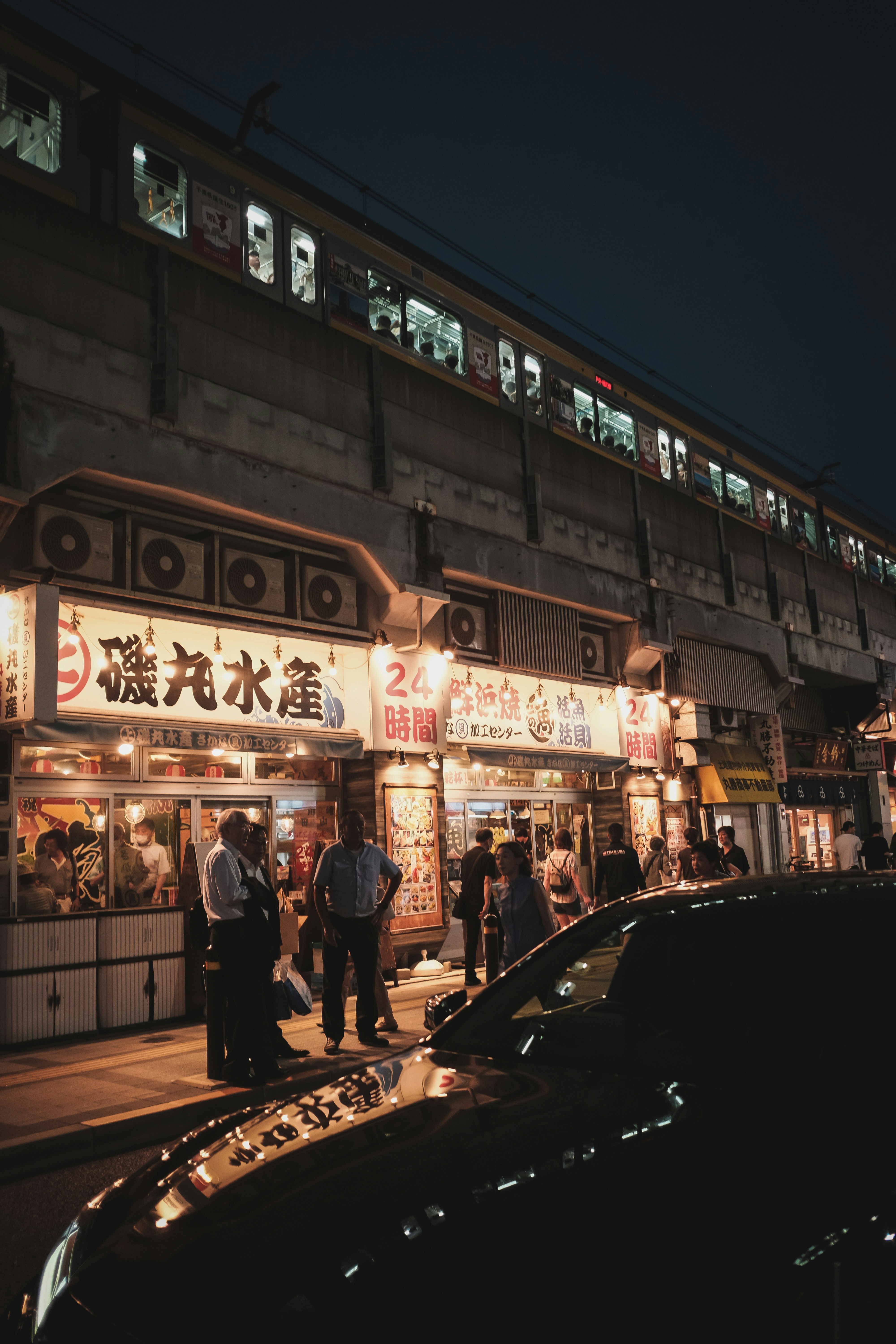 A group of people standing outside of a building at night photo – Free ...