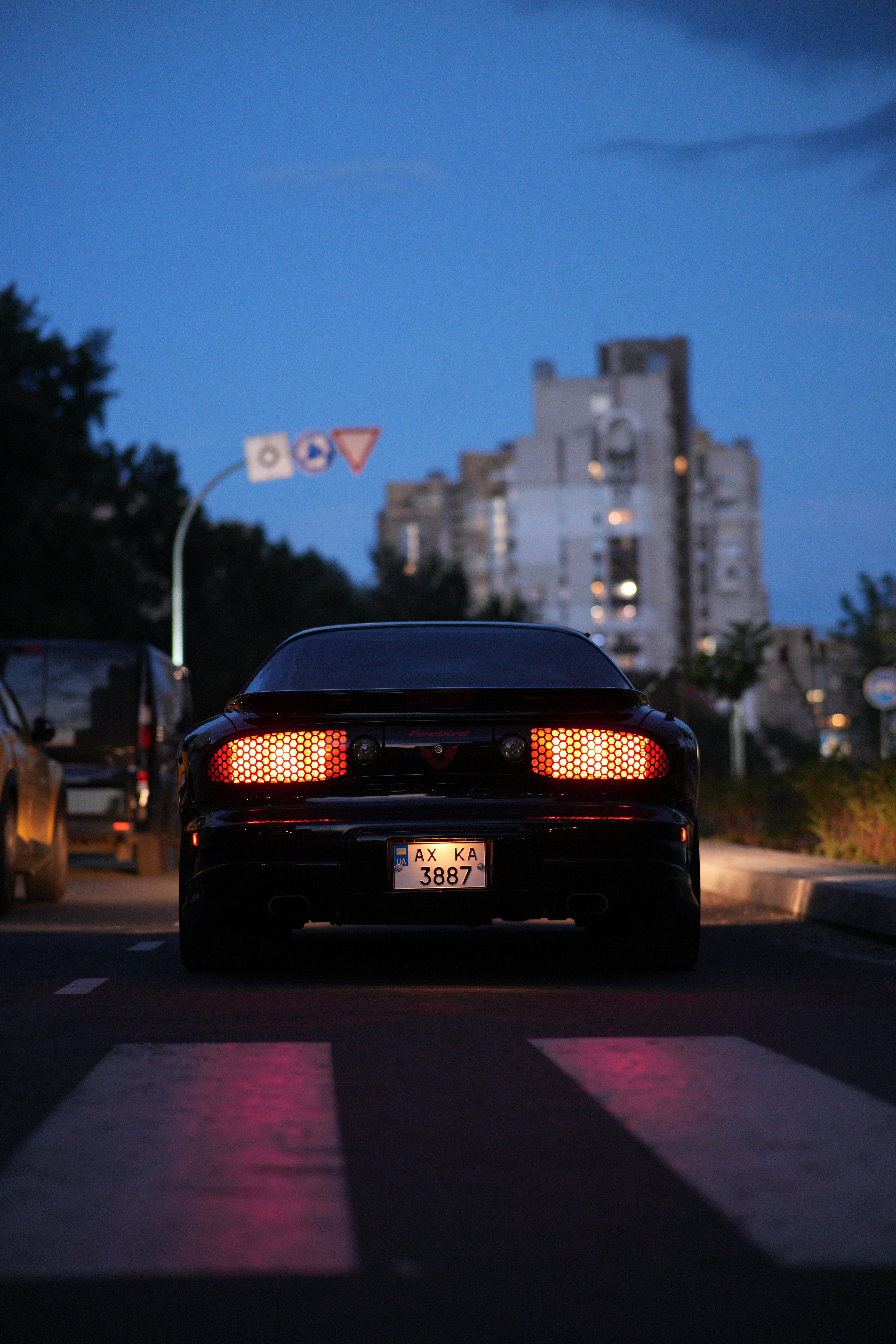 Dusk-Driven: Black Coupe Illuminates the Street with Neon Red Taillights