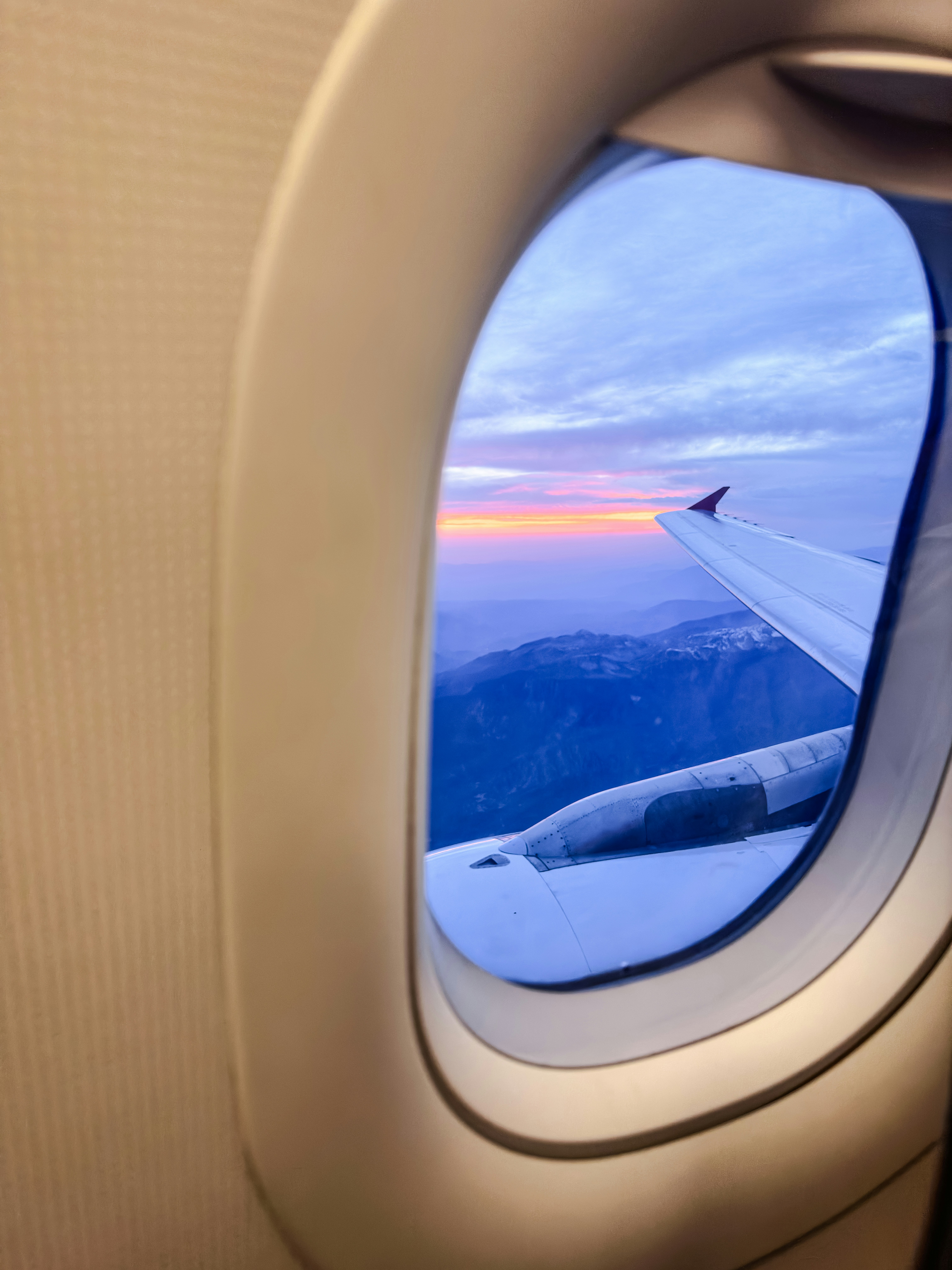 Alpine Sunset Through a Passenger Window: Wing, Sky, and Snow