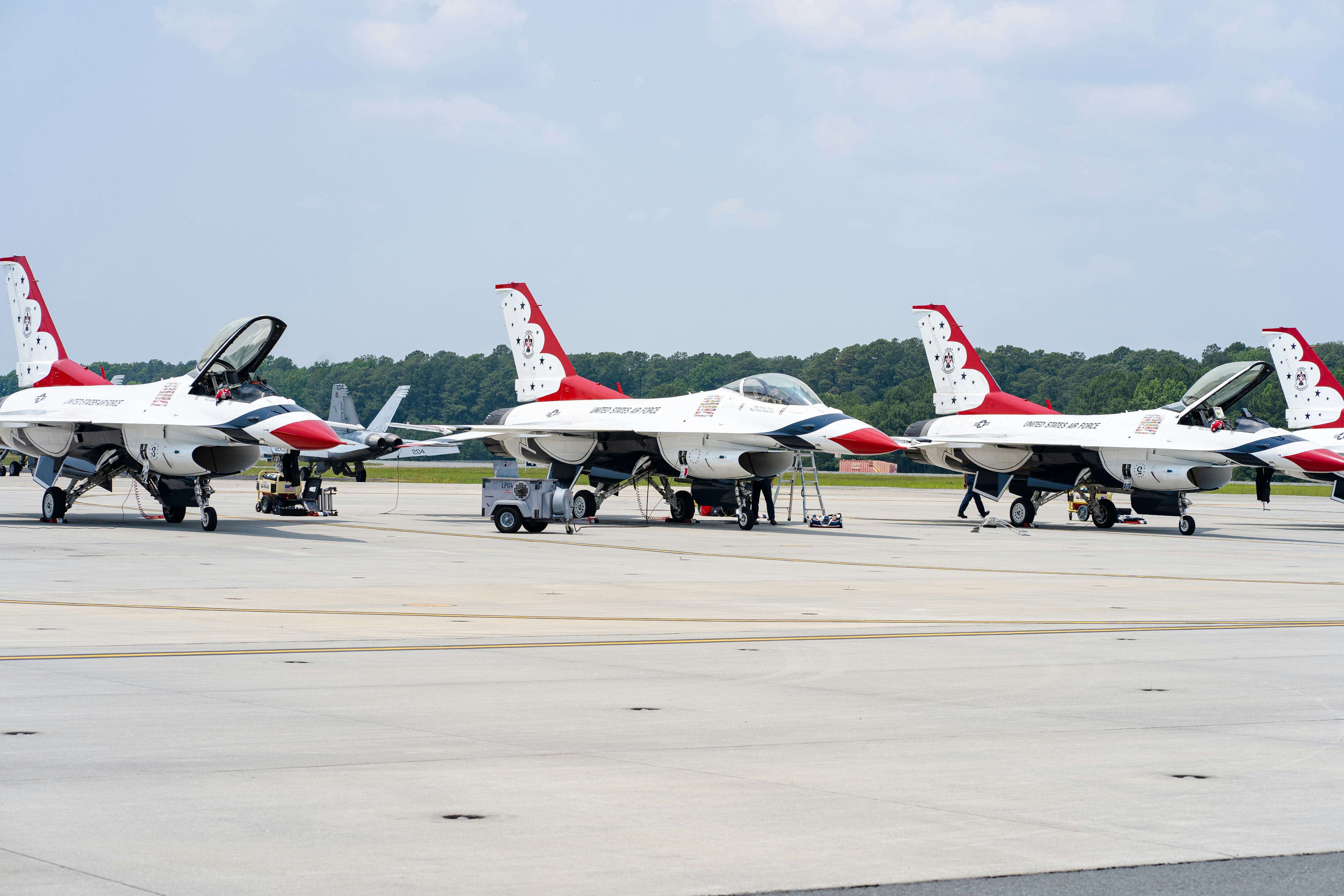 Open-Cockpit Row: Precision Jets Parked Along a Sunlit Ramp
