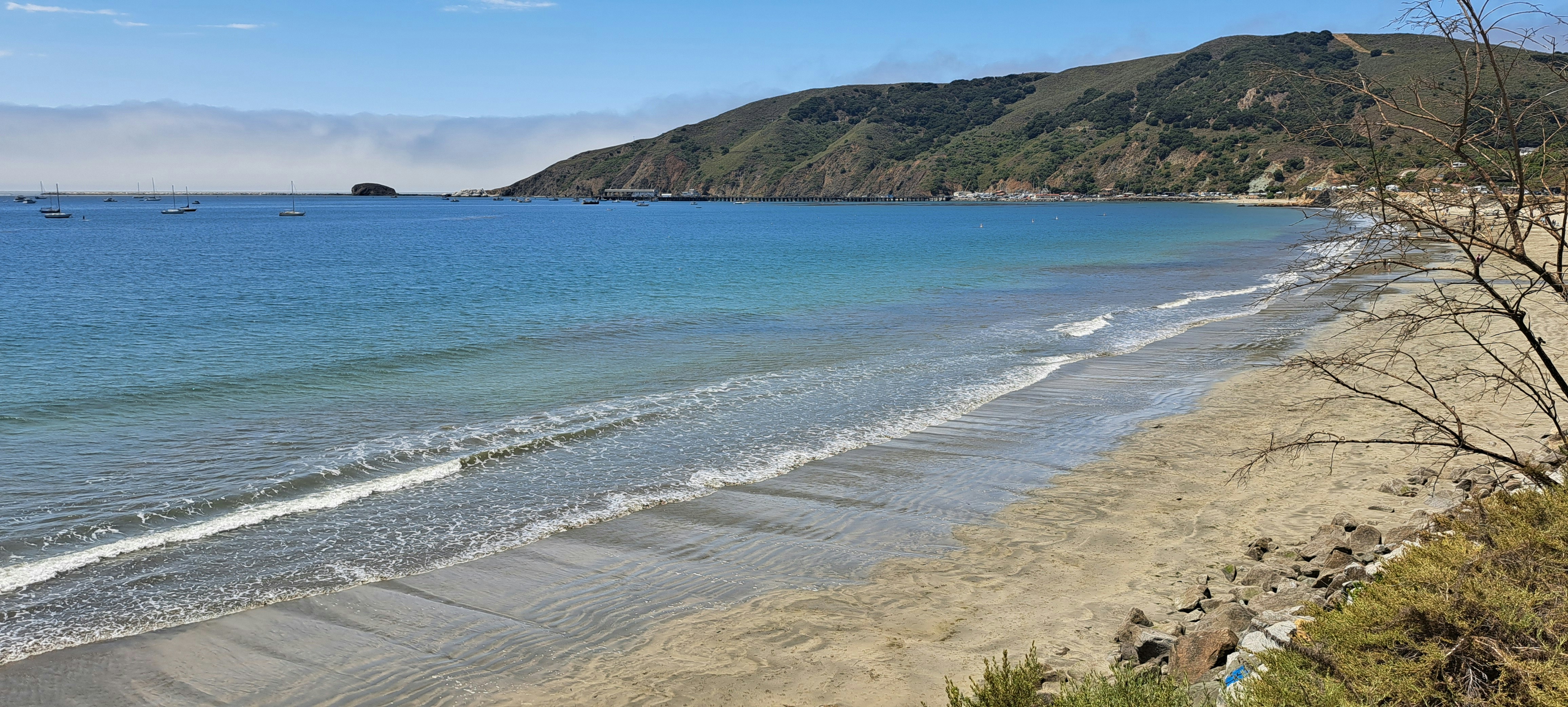 Shoreline Convergence: Waves Etch a Quiet Beach Toward Distant Hills
