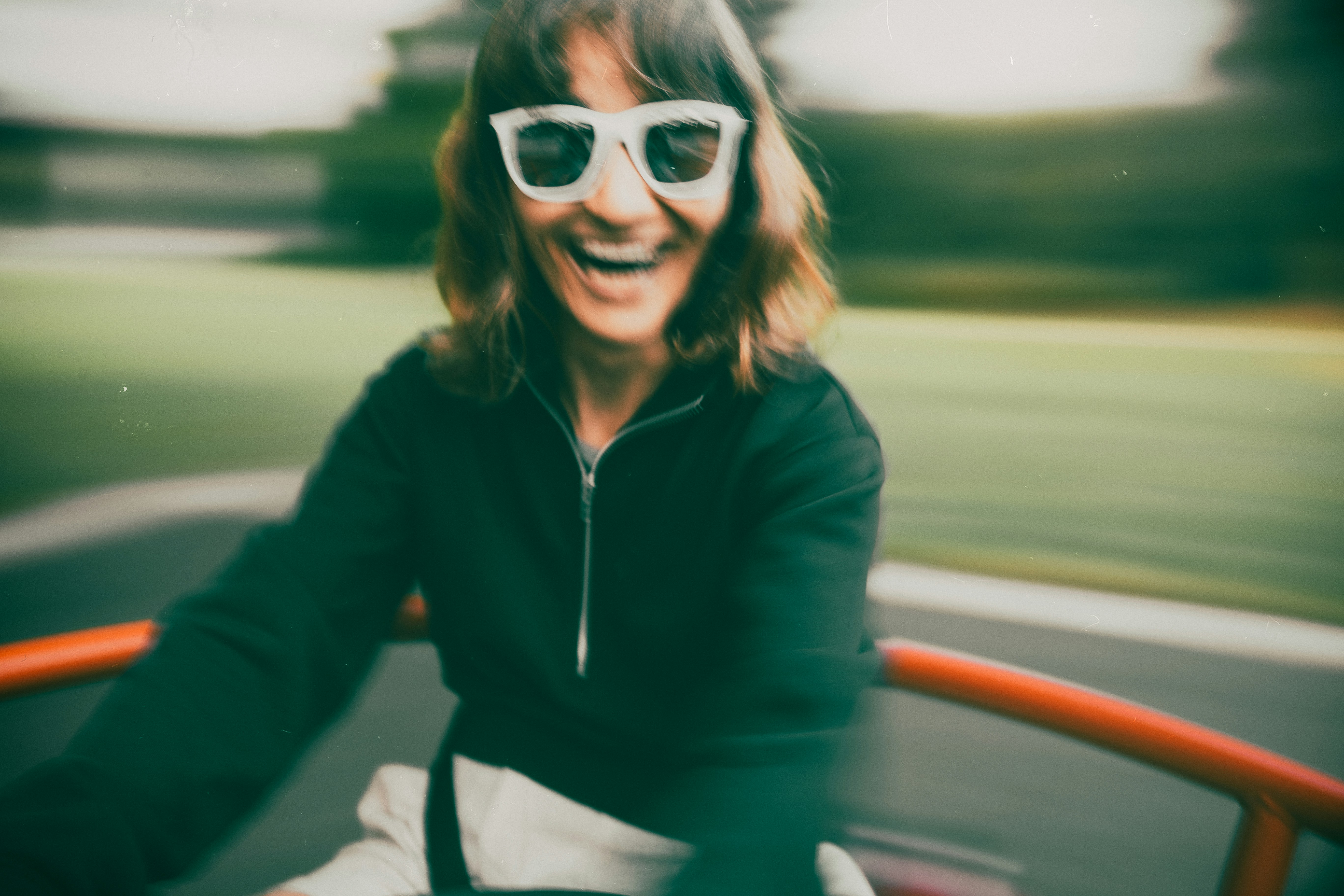 Grin in the Spin: A Wind-Blurred Park Ride Moment
