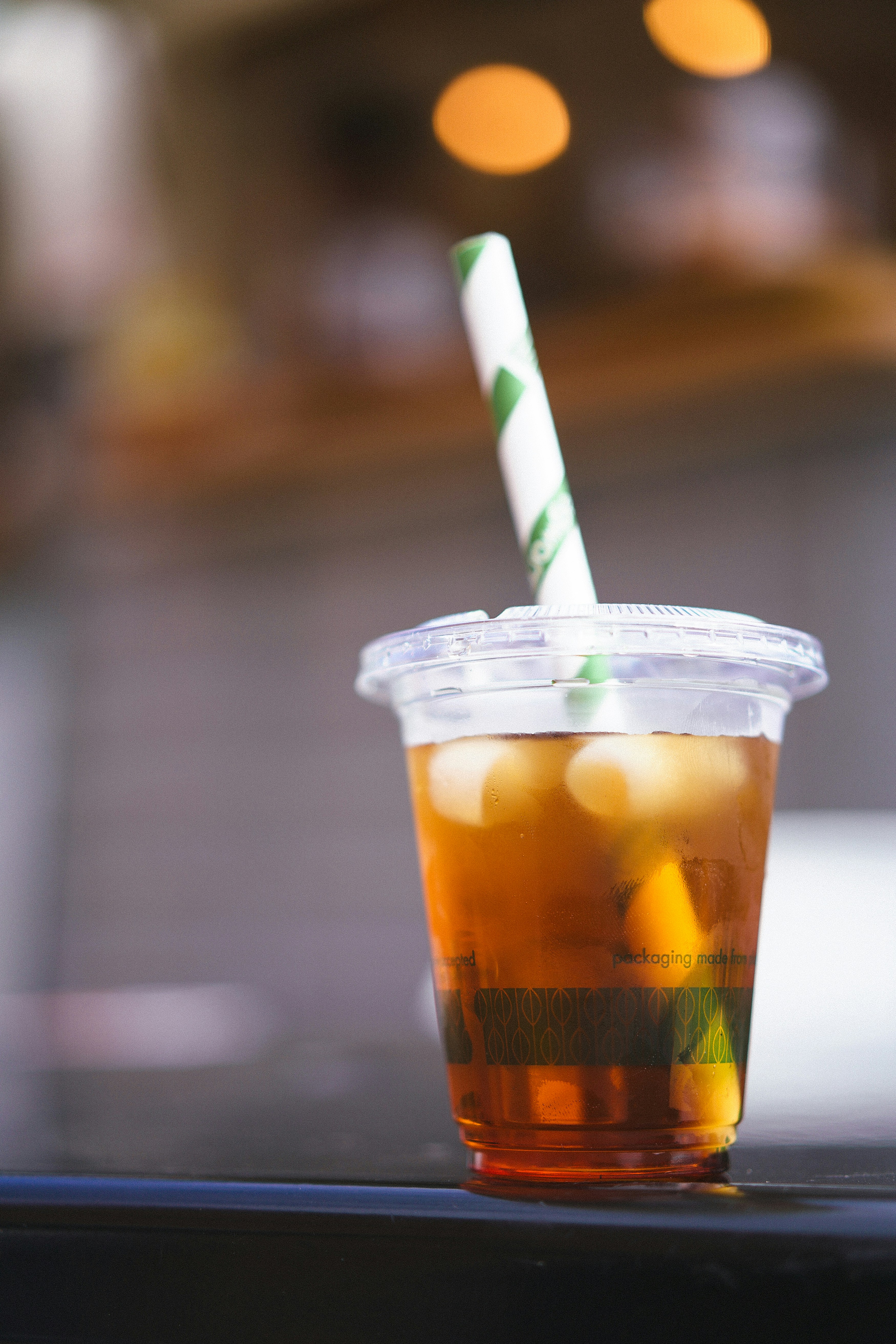 A cup of iced tea with a green and white striped straw photo – Free ...