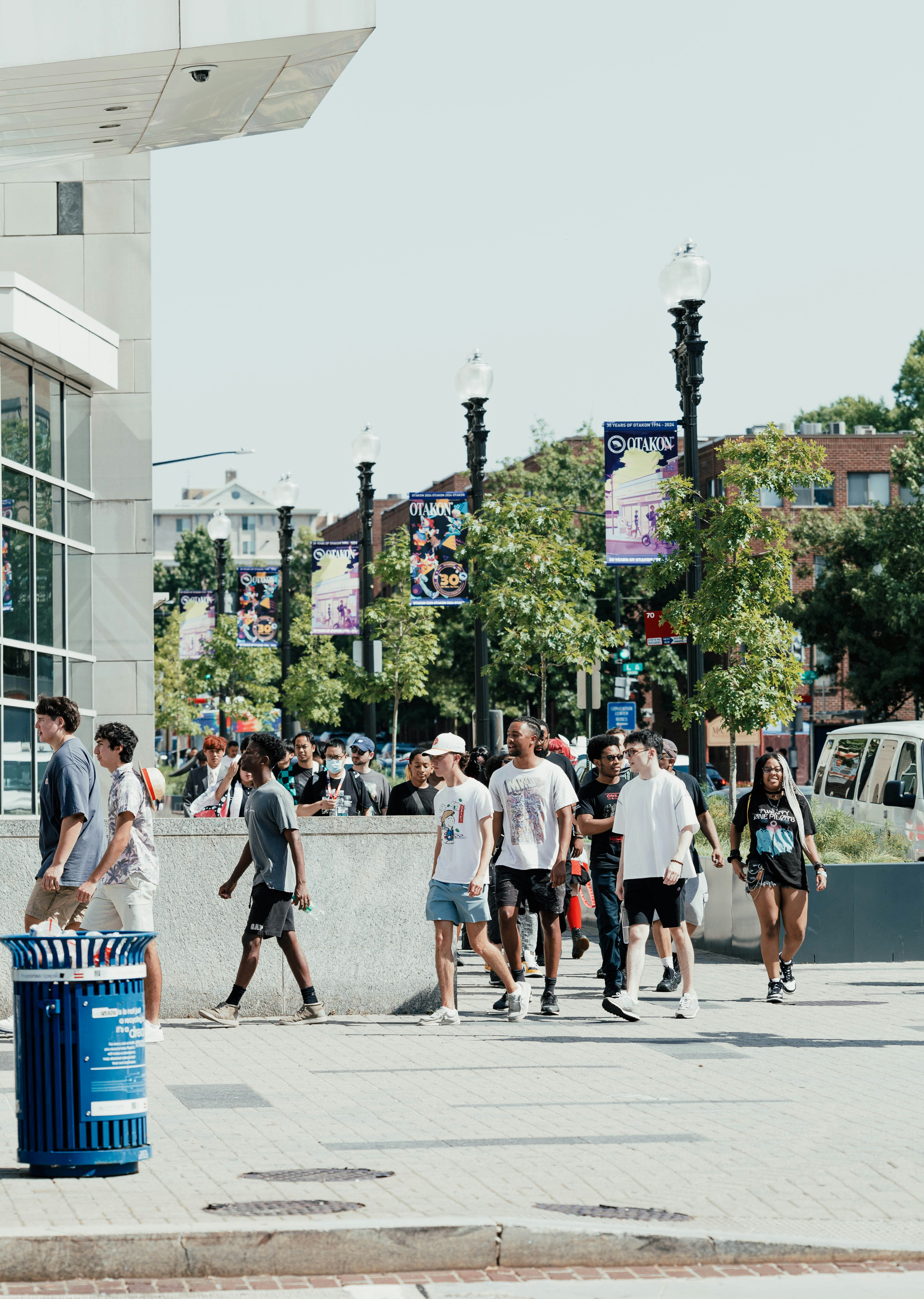 Morning Flux: Pedestrians Move Through a Bannered Urban Plaza