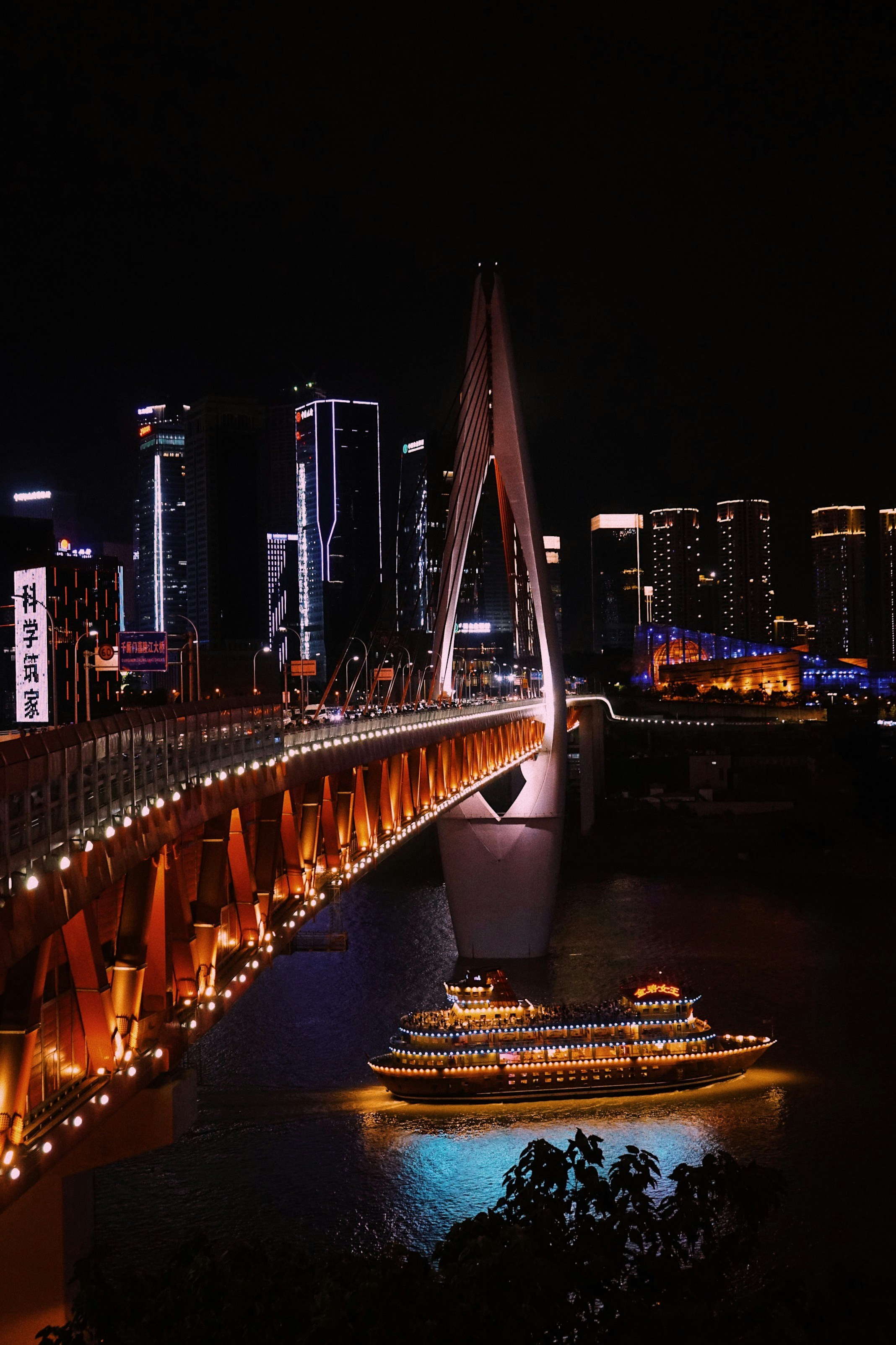Chongqing Bridge at night, with a cruise traveling under