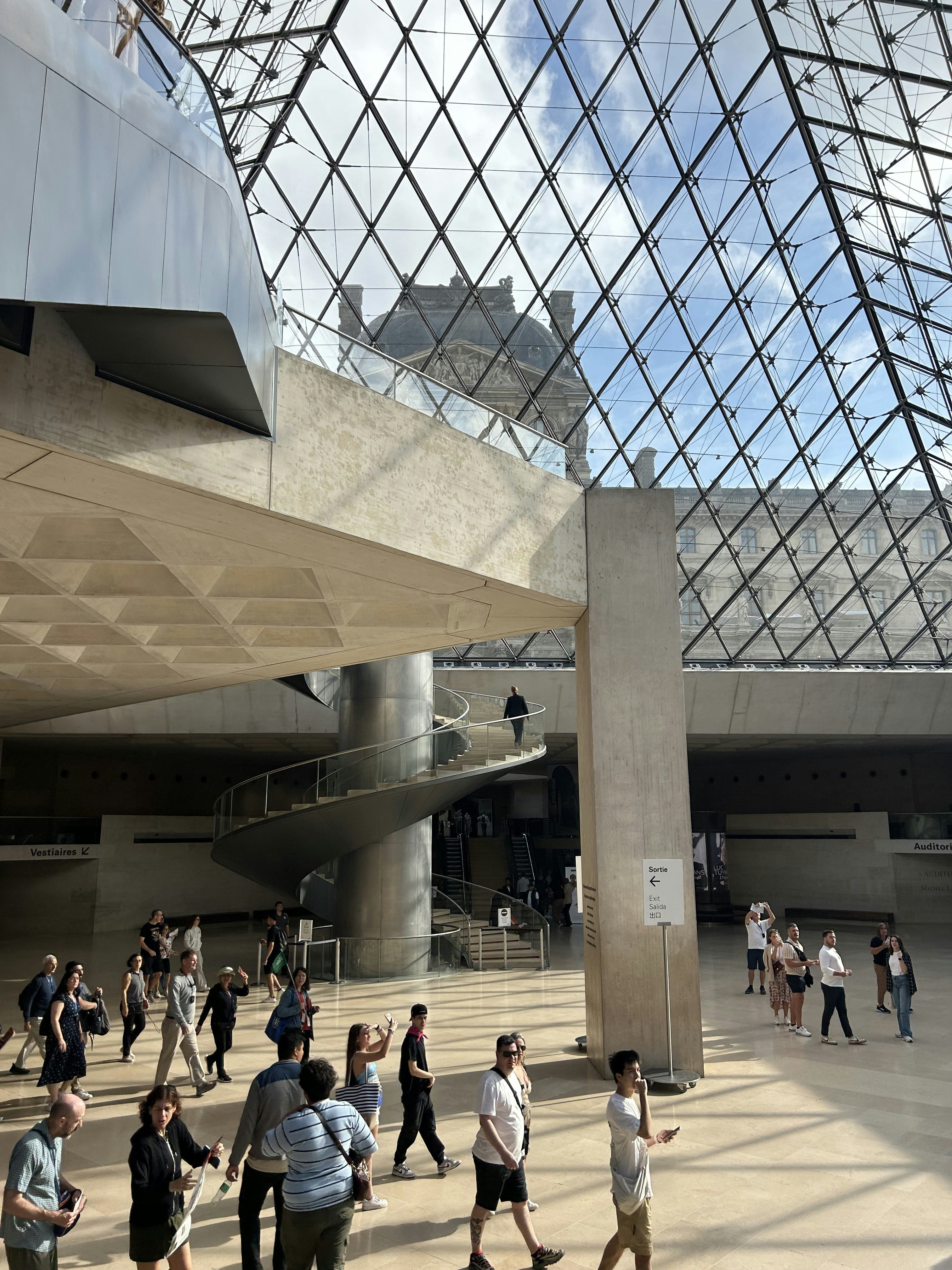 A group of people walking around inside of a building photo – Free ...
