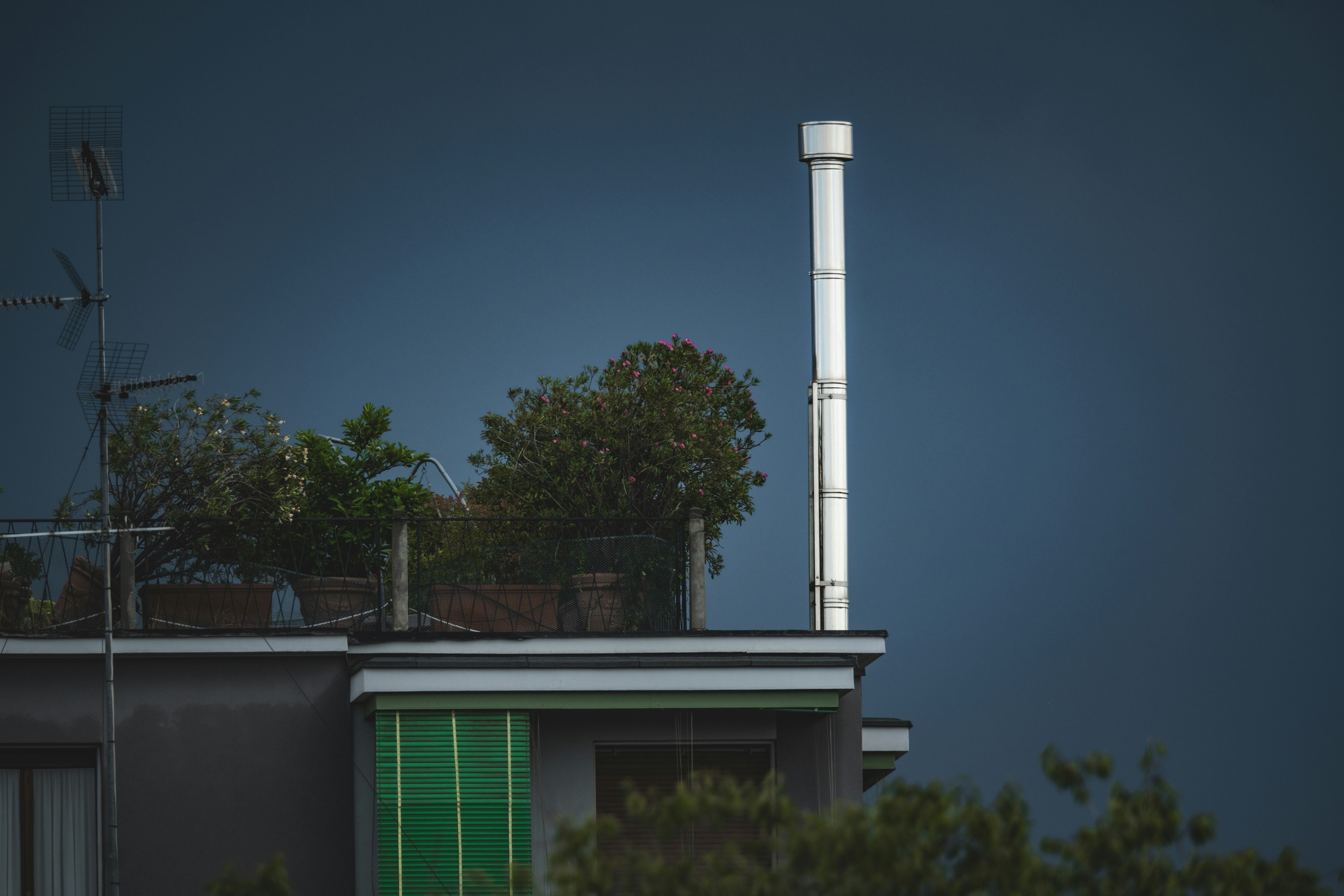 Chimney Spire at the Rooftop Edge Under a Deep Indigo Sky