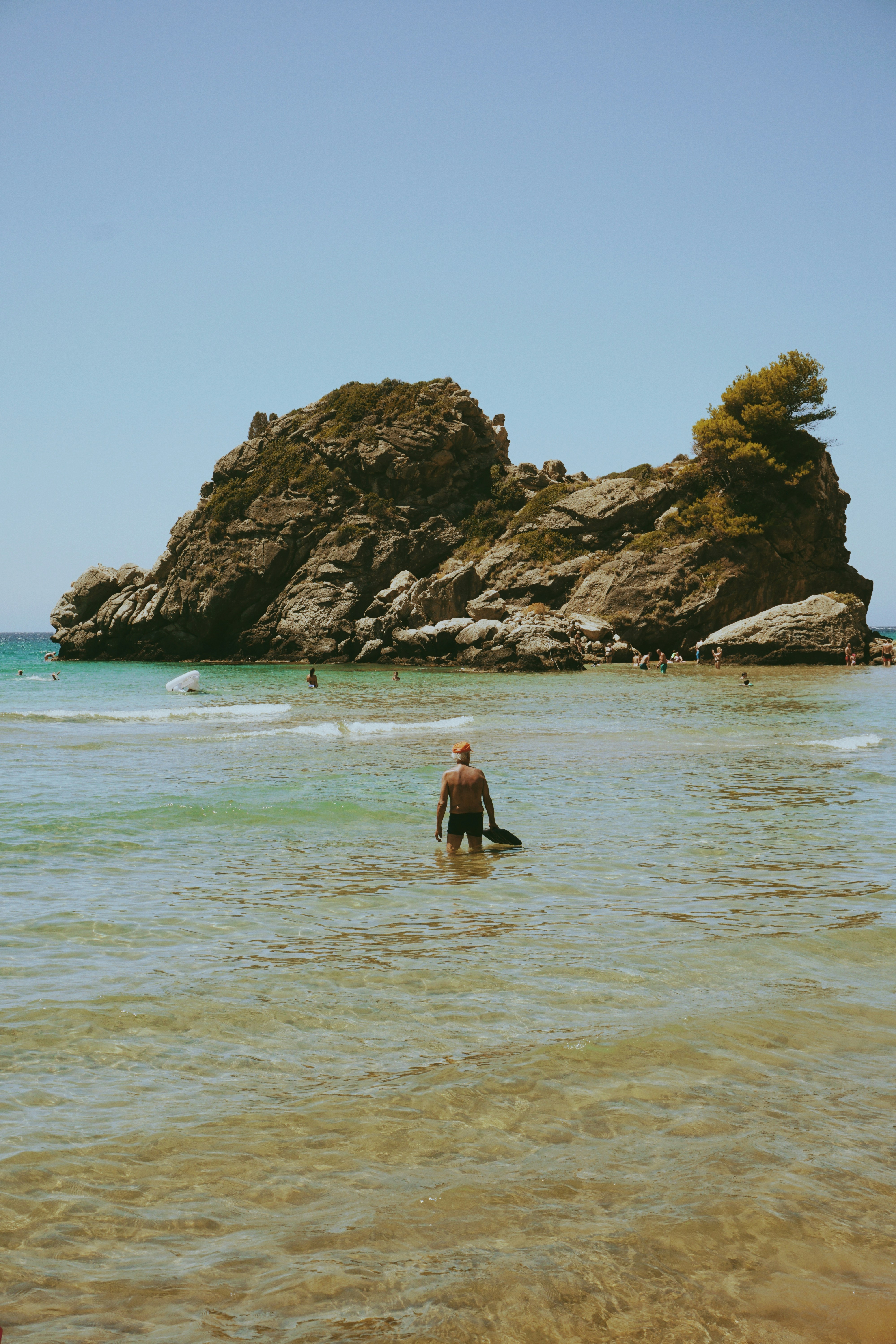 Solitary Figure at the Edge of Clear Waters Before the Granite Sentinel