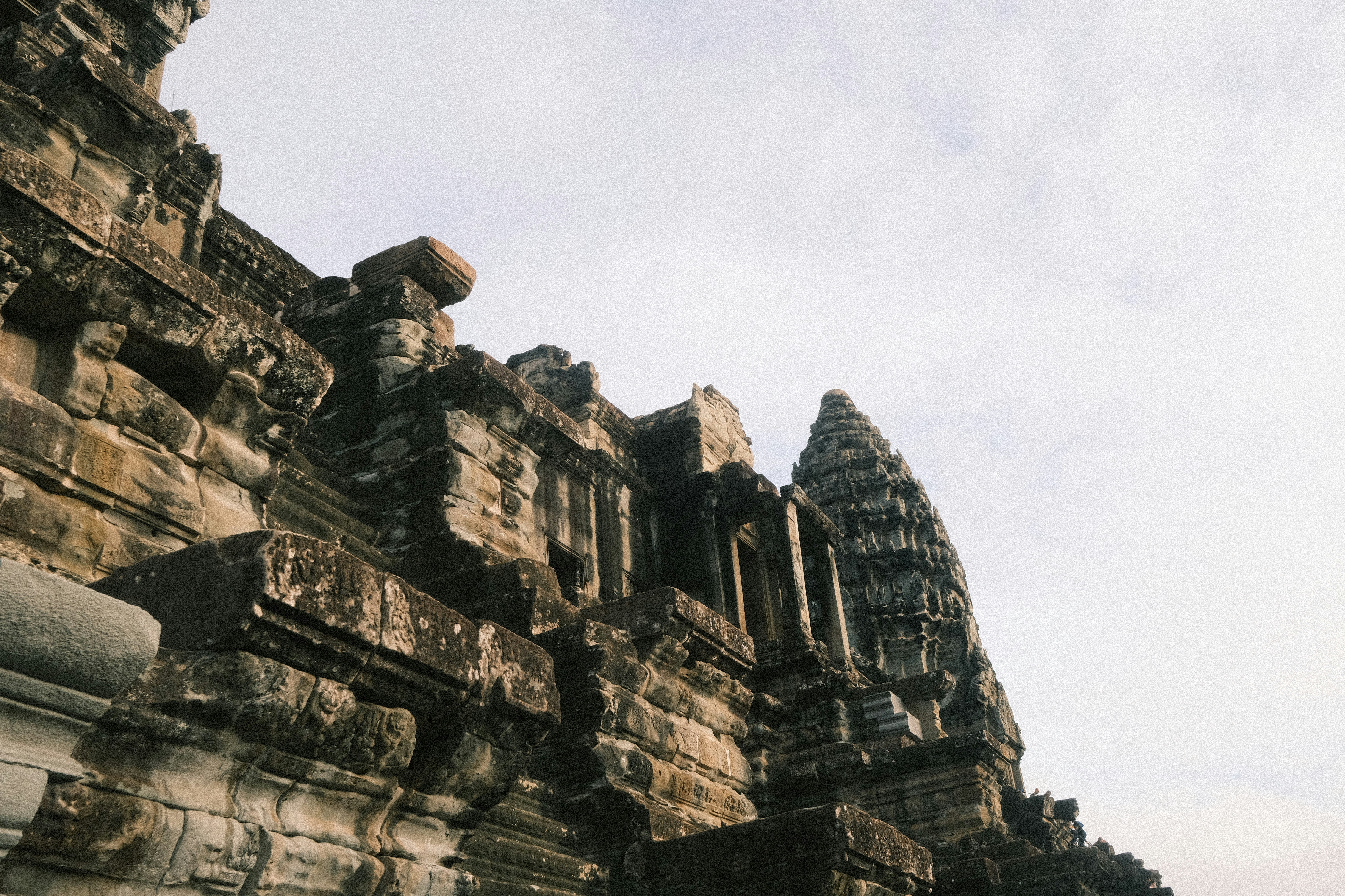A large stone building with a clock on it's side photo – Free Angkor ...