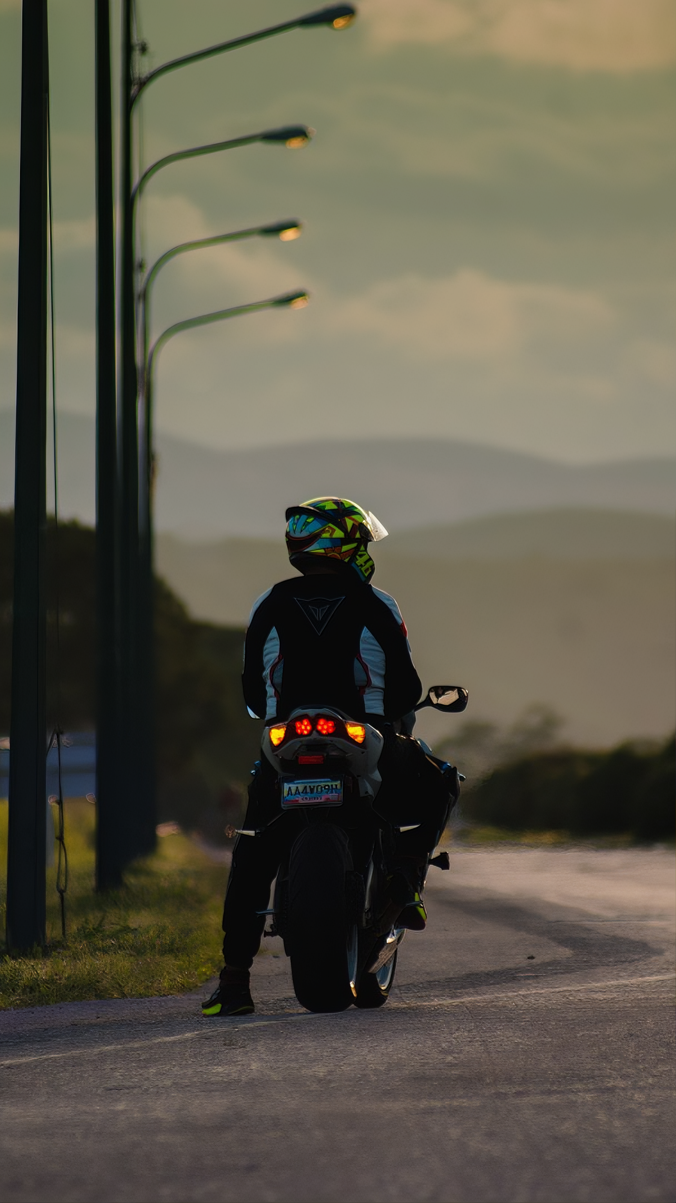 A person riding a motorcycle down a street photo – Free Motorbike Image ...