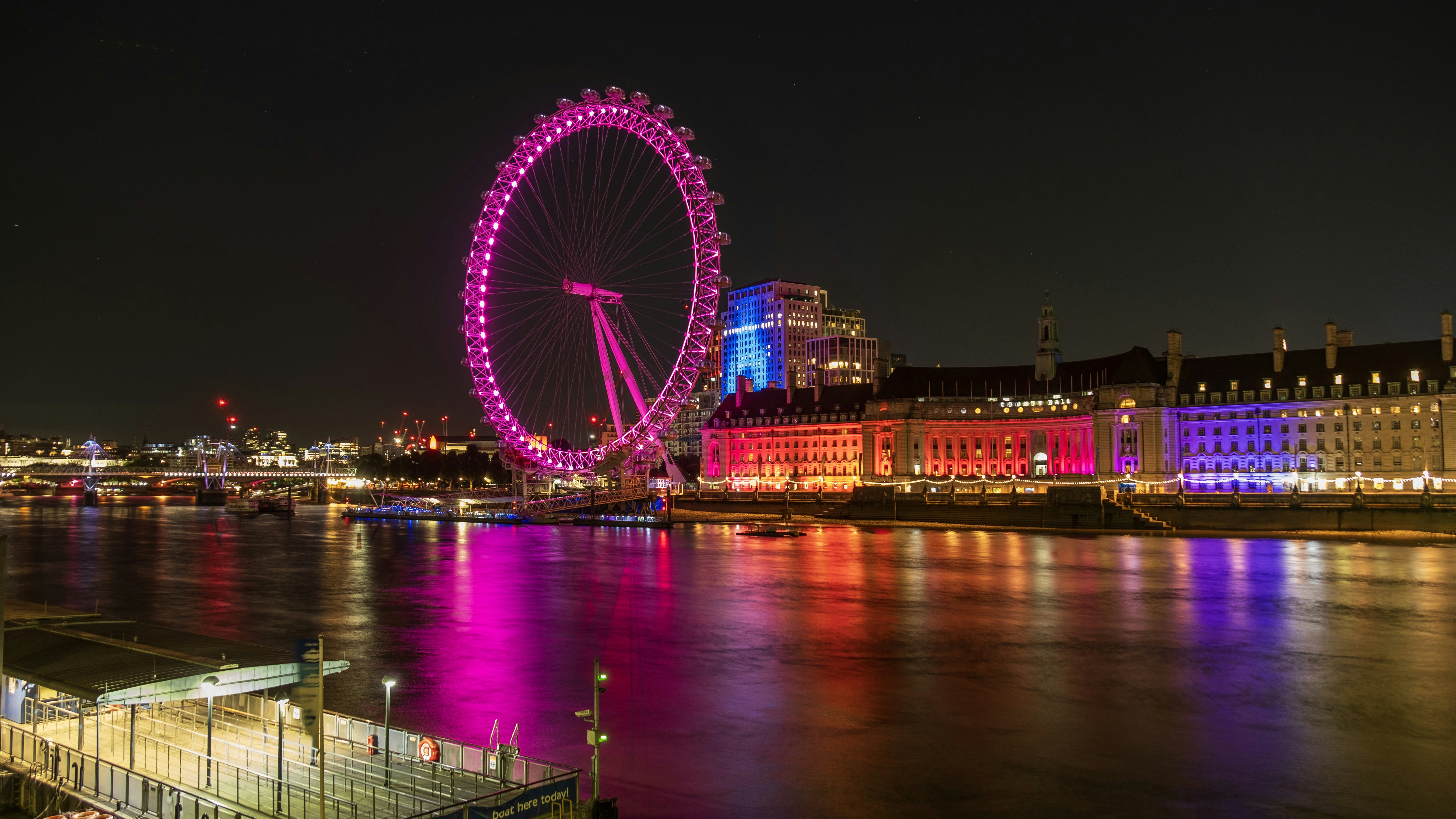 The London Eye at night with the River Thames in the foreground
