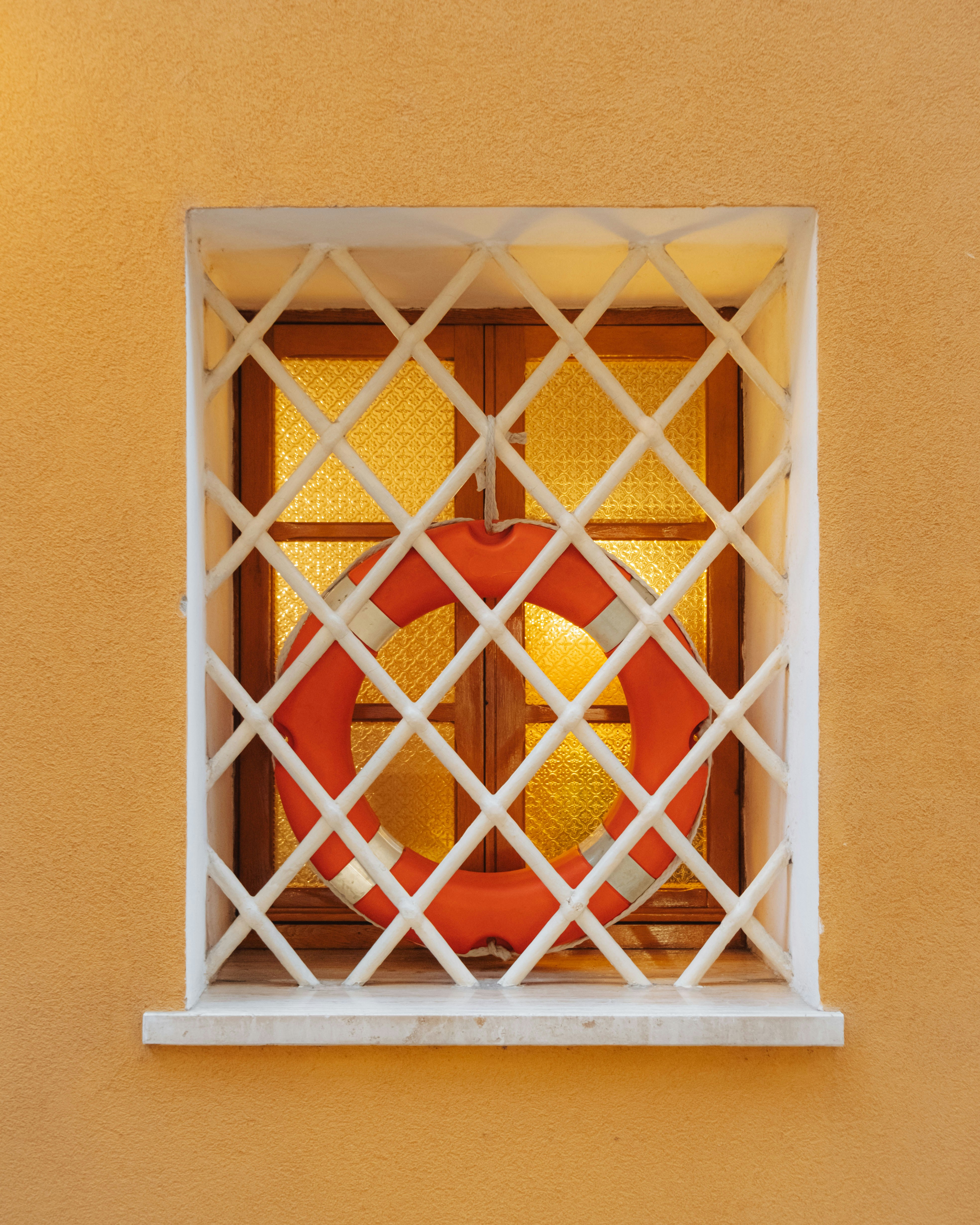 Lifebuoy in a Diamond-Latticed Window Bathed in Sunlit Amber Glass