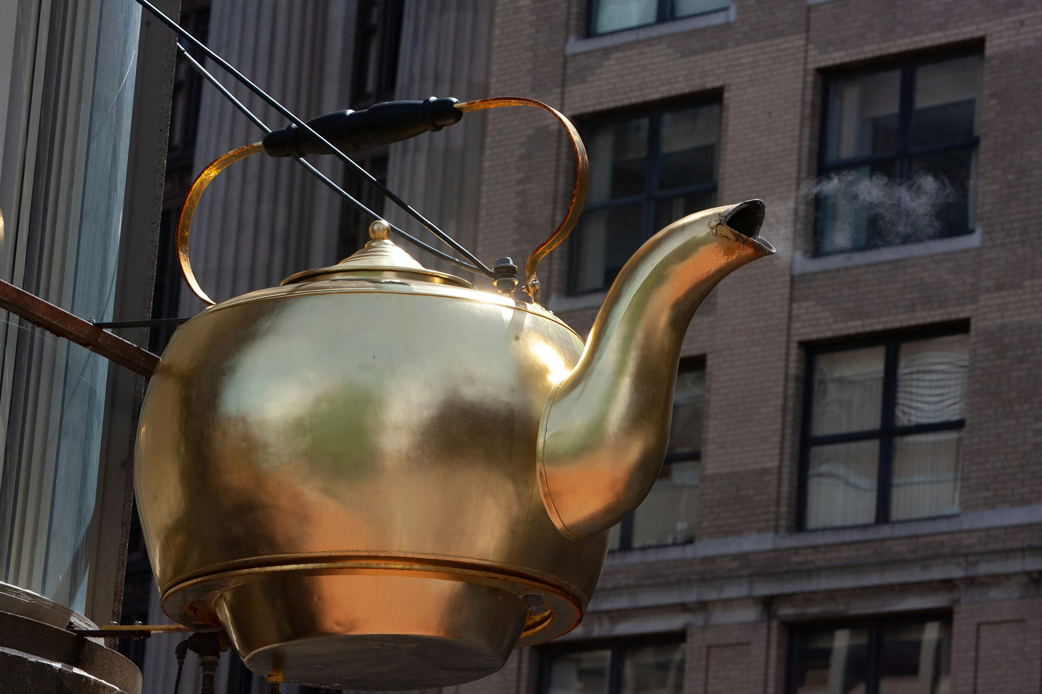 A gold teapot hanging from the side of a building photo – Free Boston ...